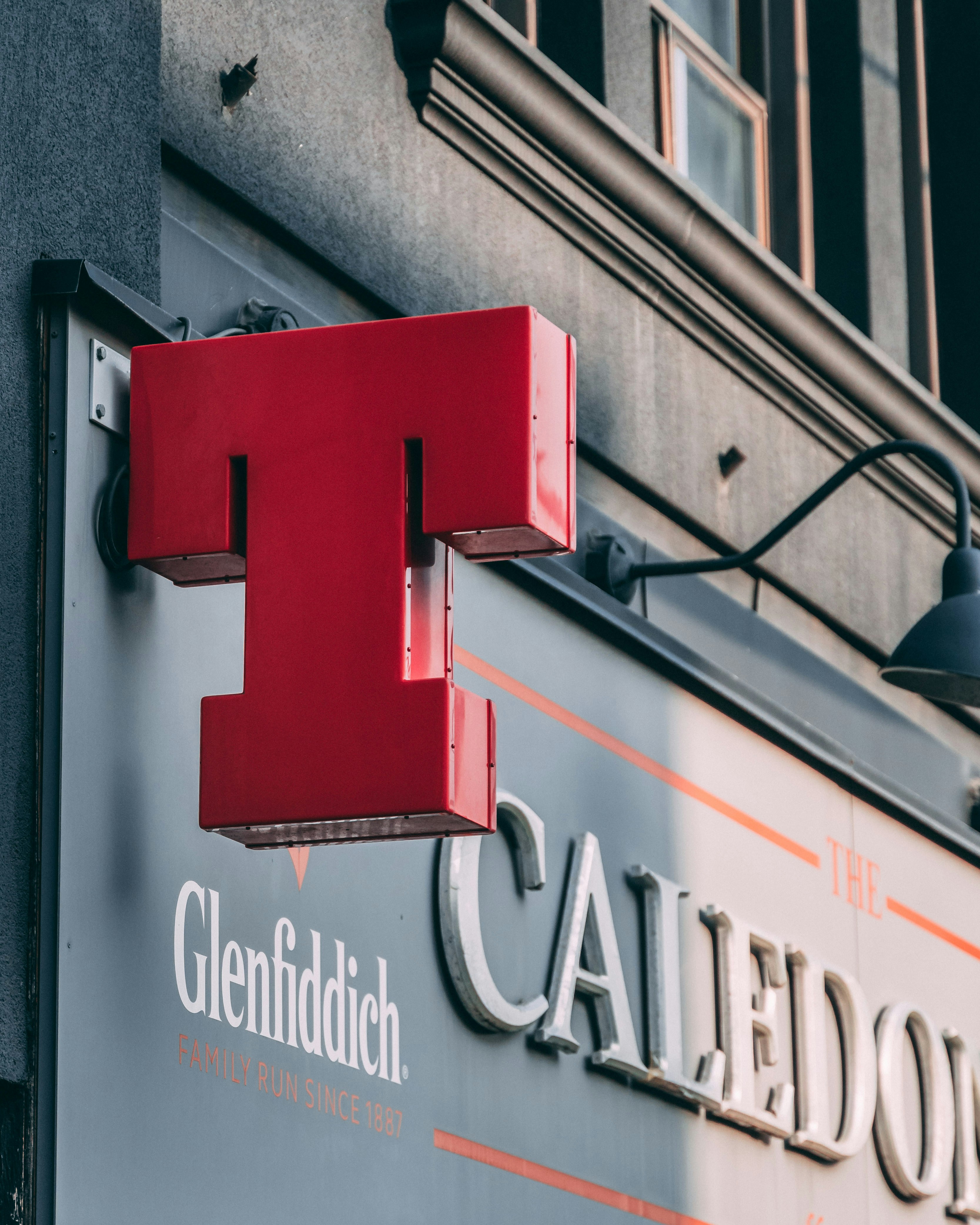 Crimson T Adorns a City Facade: A Bold Signage Moment