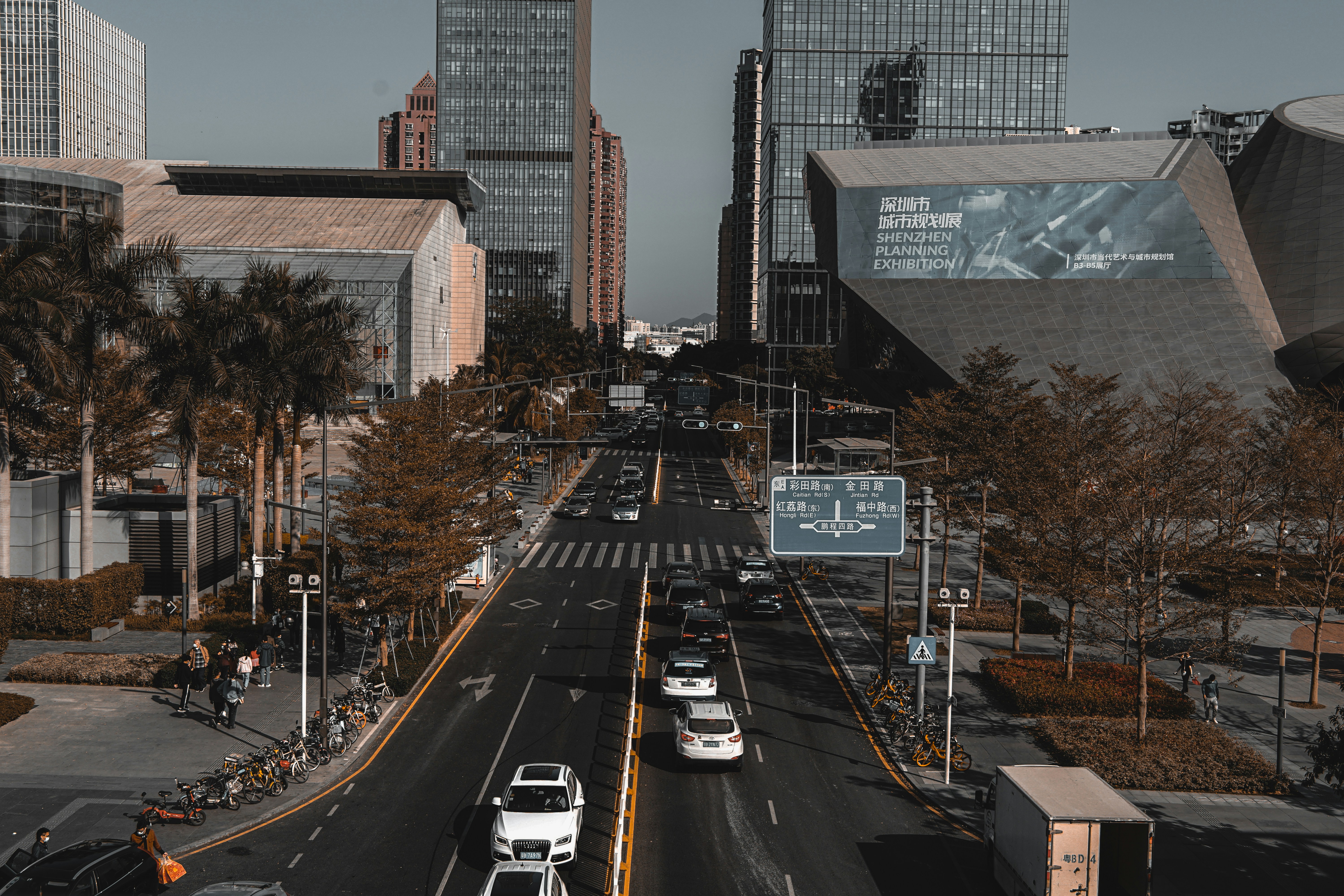 City street bustling with cars and surrounded by modern skyscrapers under a clear sky.