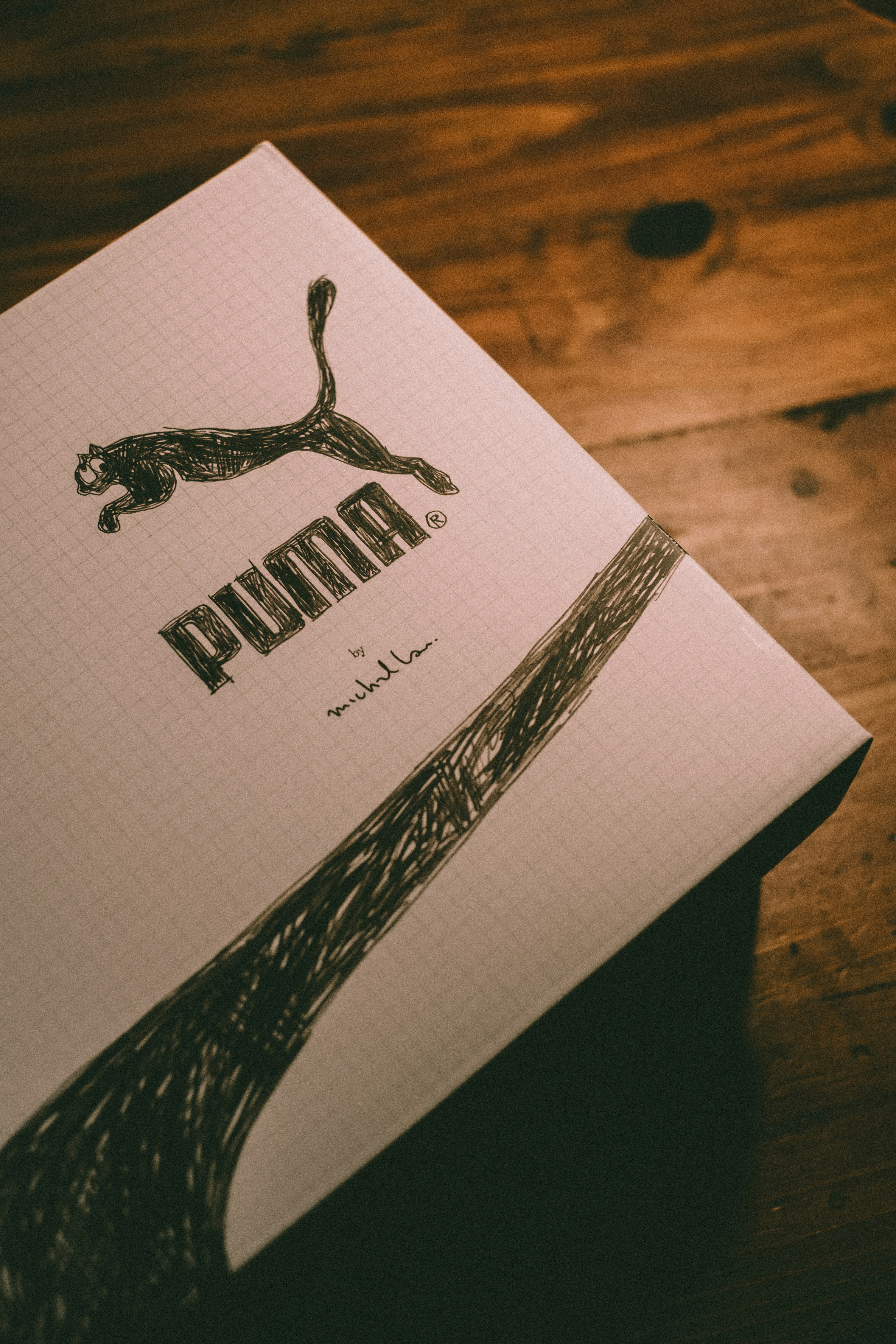 Leaping Ink: A Graph-Notebook Puma Logo Resting on Warm Wood