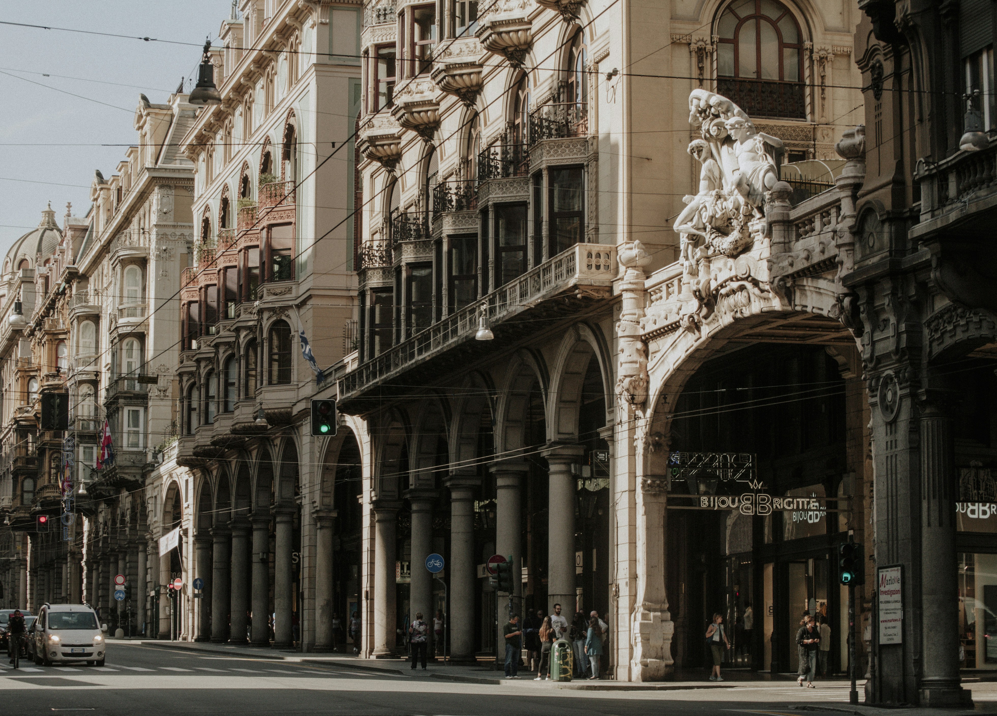 Historic European architecture with ornate sculptures lining a sunlit street.