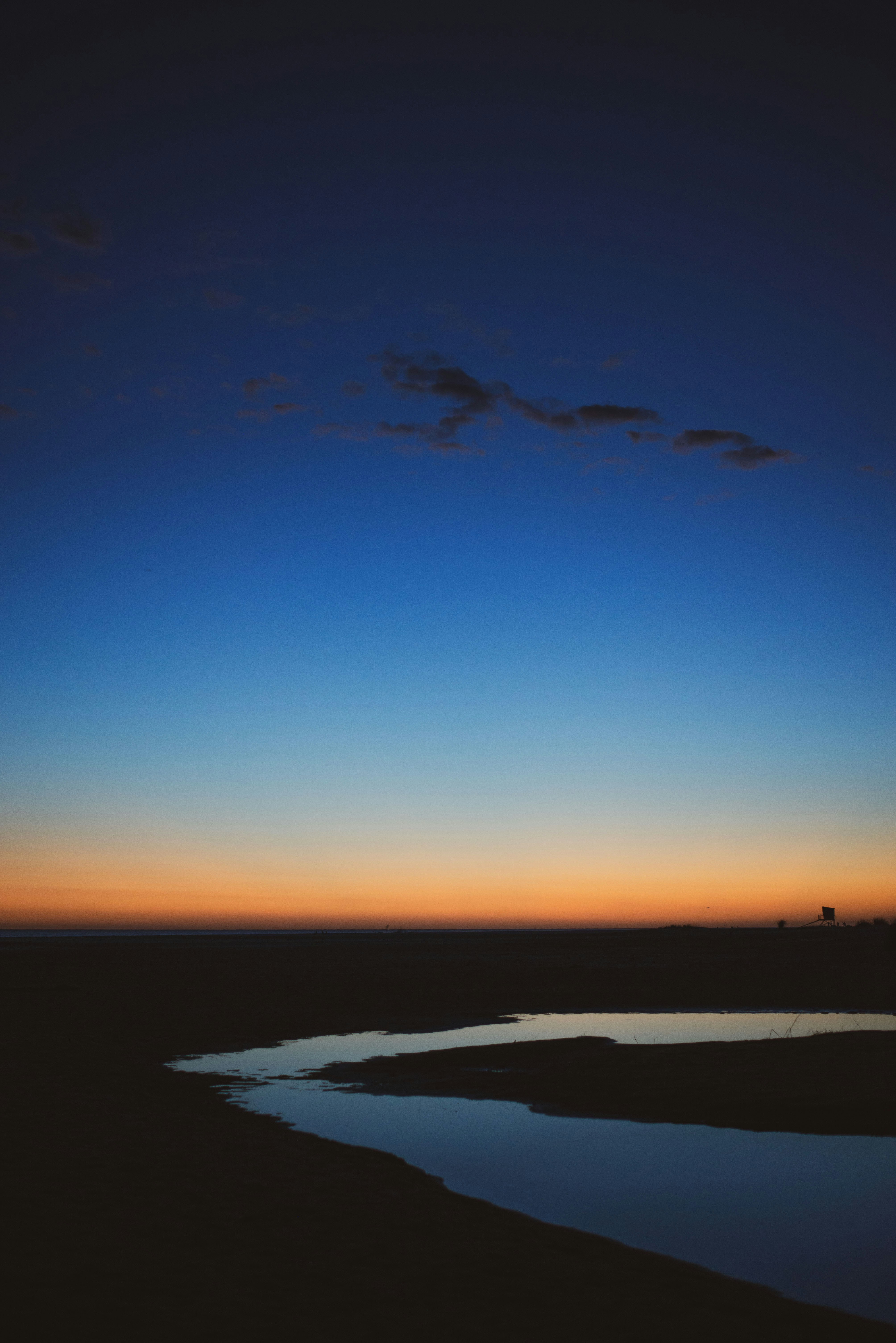 Horizon Ember Over a Silent Riverbank at Dusk