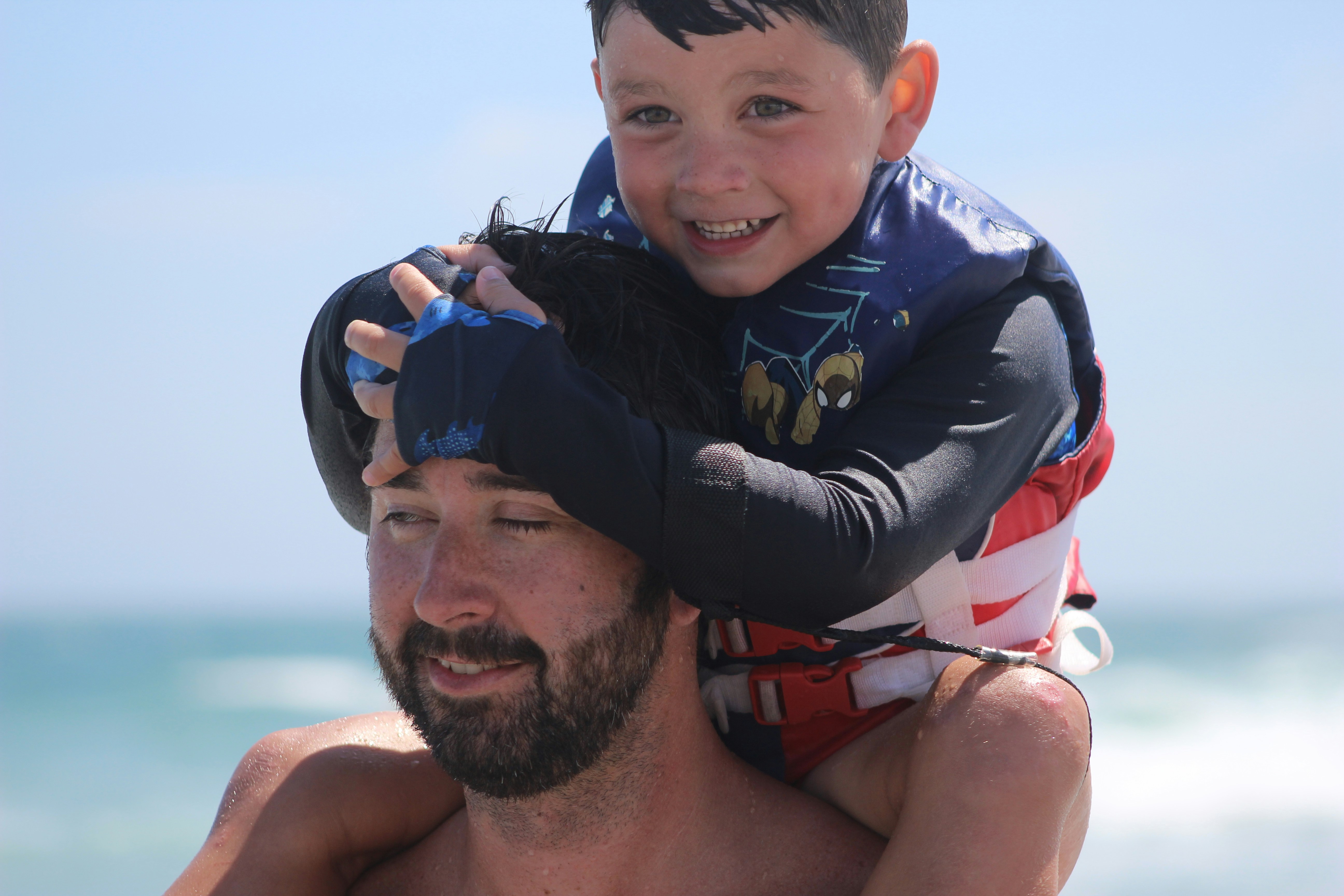 A dad with his boy. | man in blue and white helmet beside man in black and white shorts