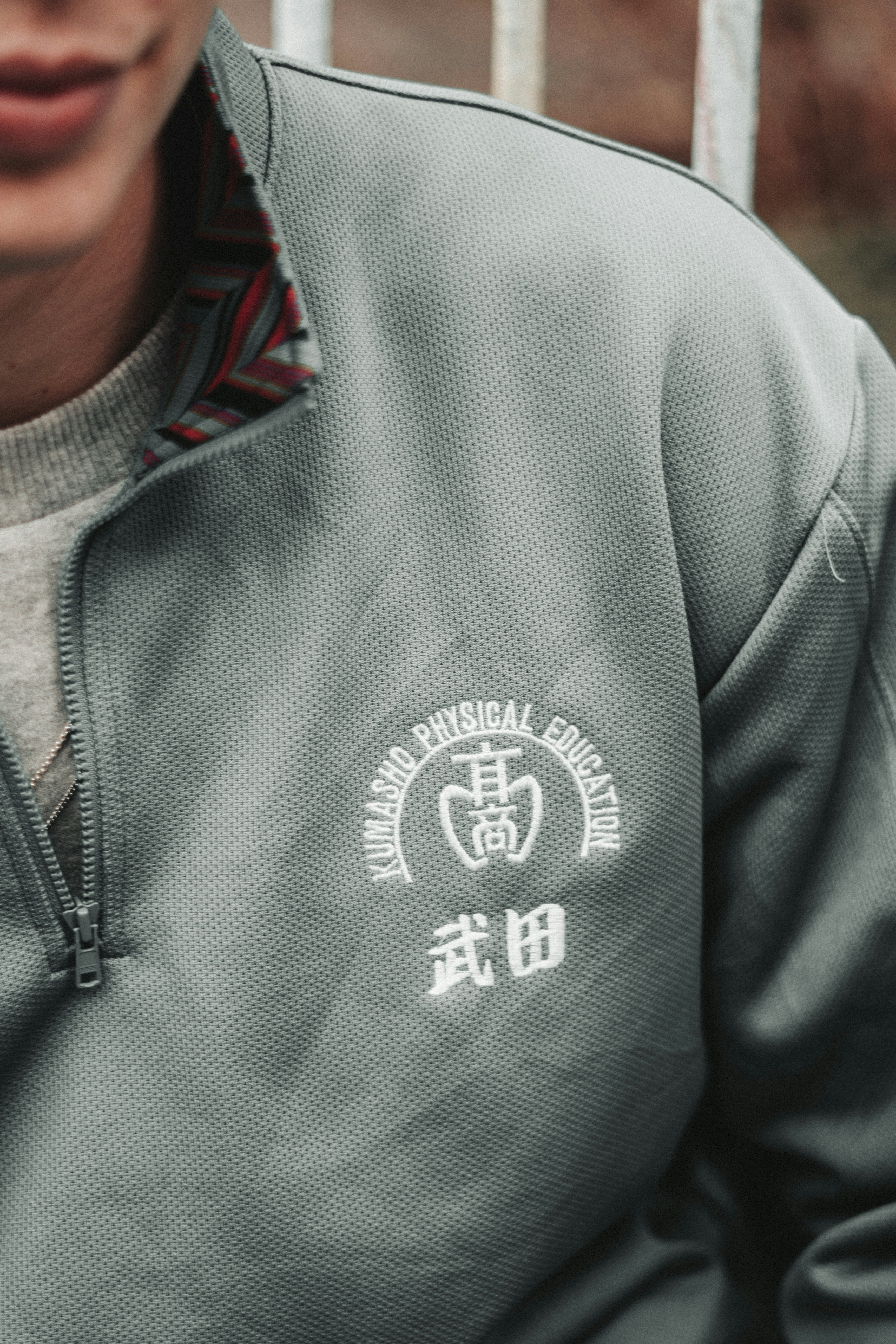 Close-up of a varsity jacket logo and partial smile