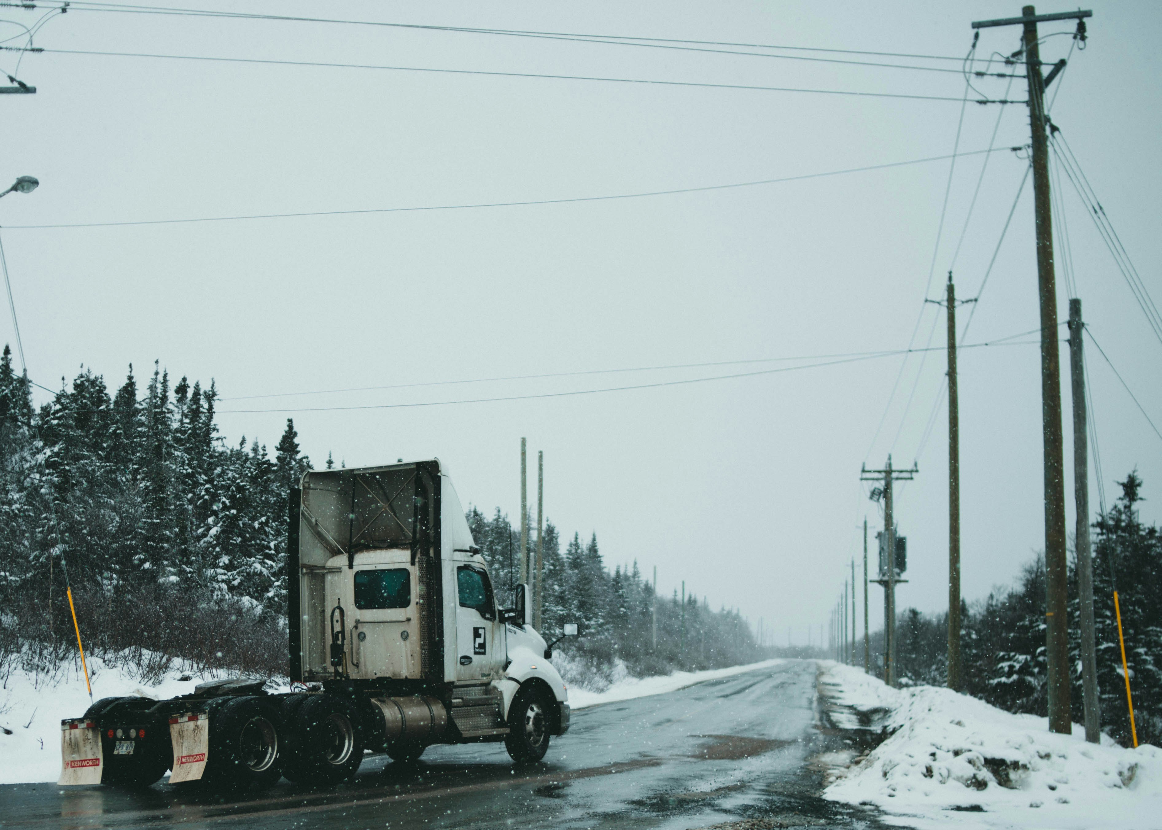 Snowbound Haul: A Lone Tractor-Trailer on a Snow-Choked Rural Road