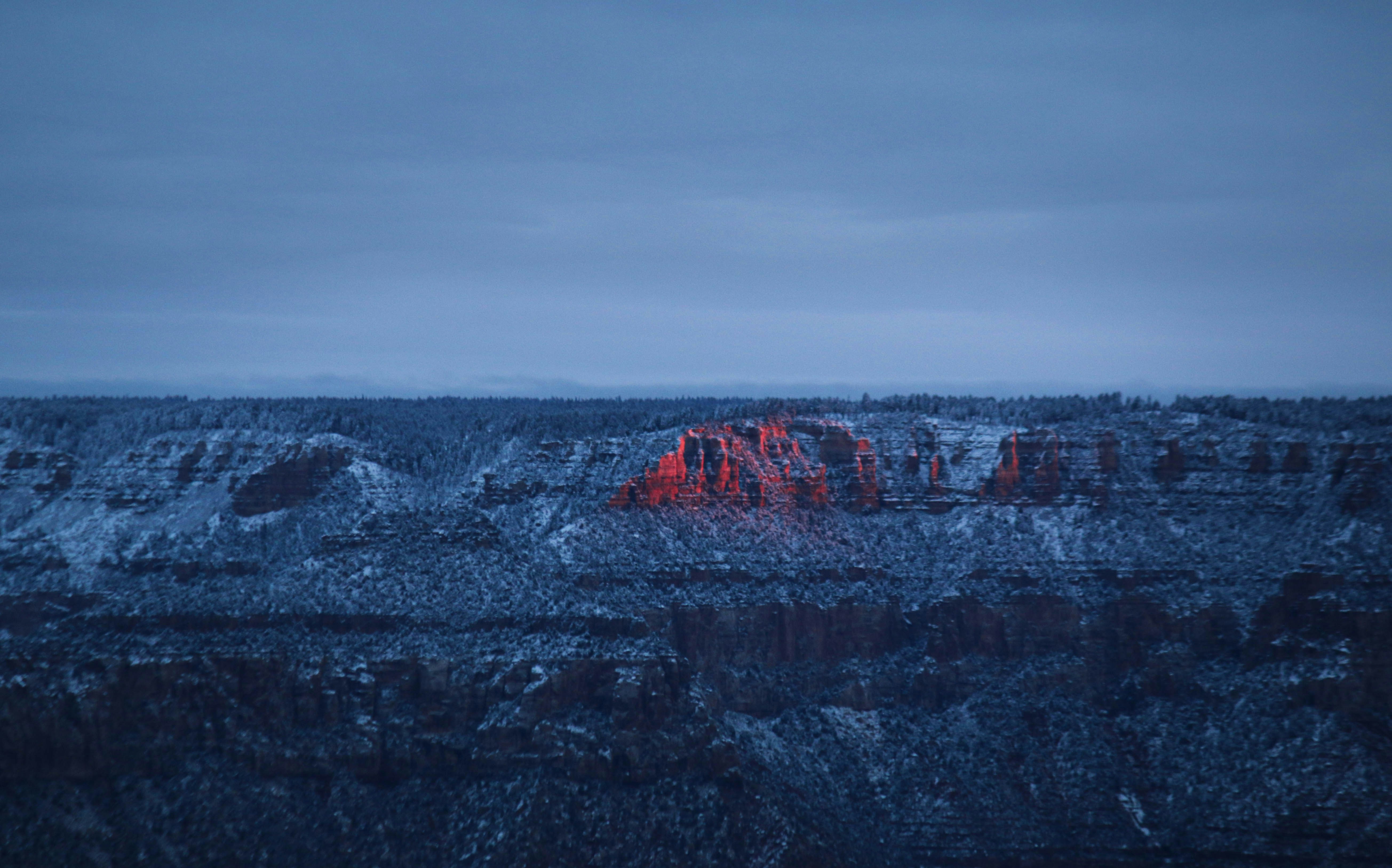 Red Ember Crowned by Snow on a Blue Canyon Crest