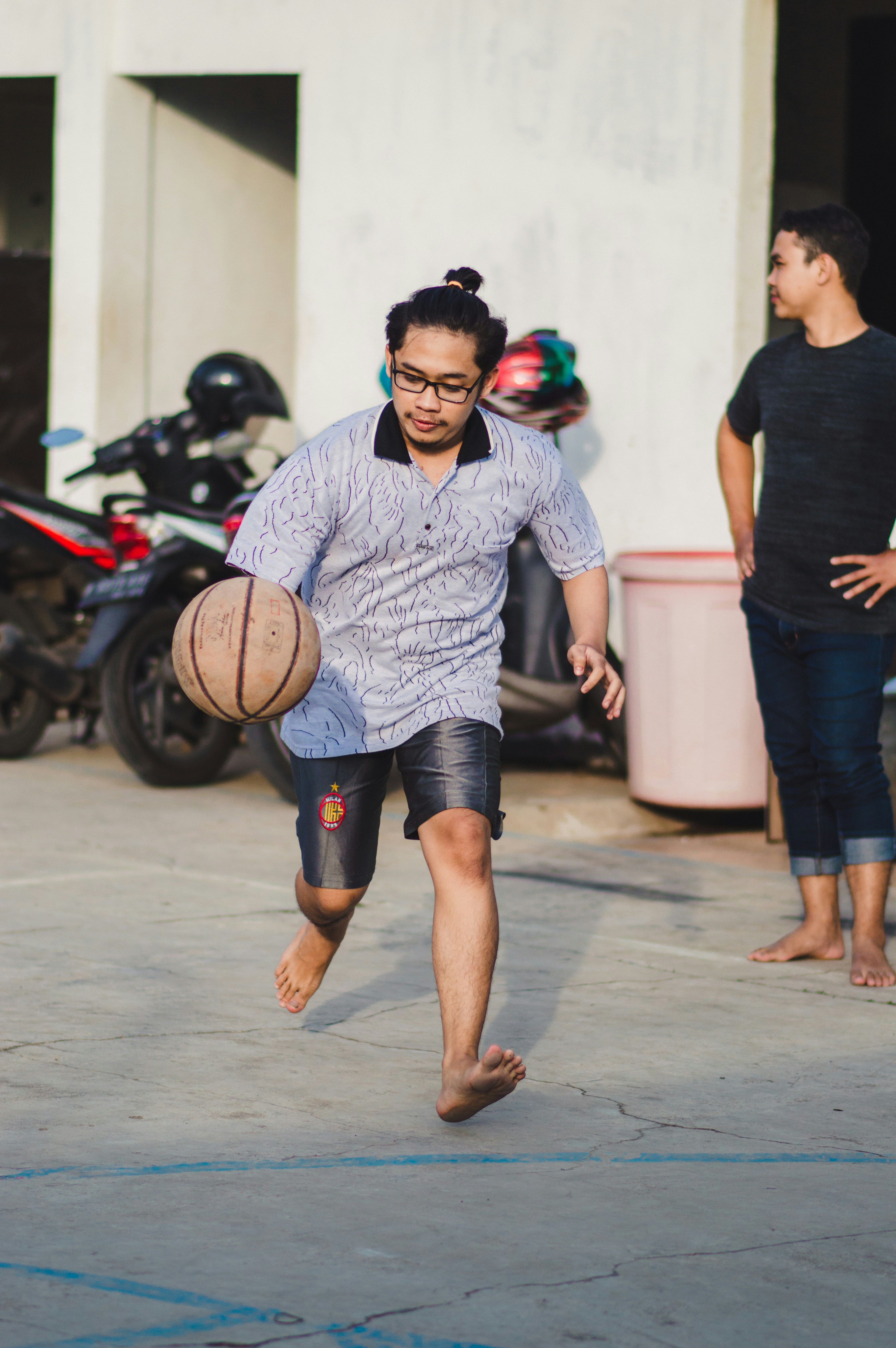 Barefoot Drive on a Sunlit Court: Focused Dribble Amid Onlookers