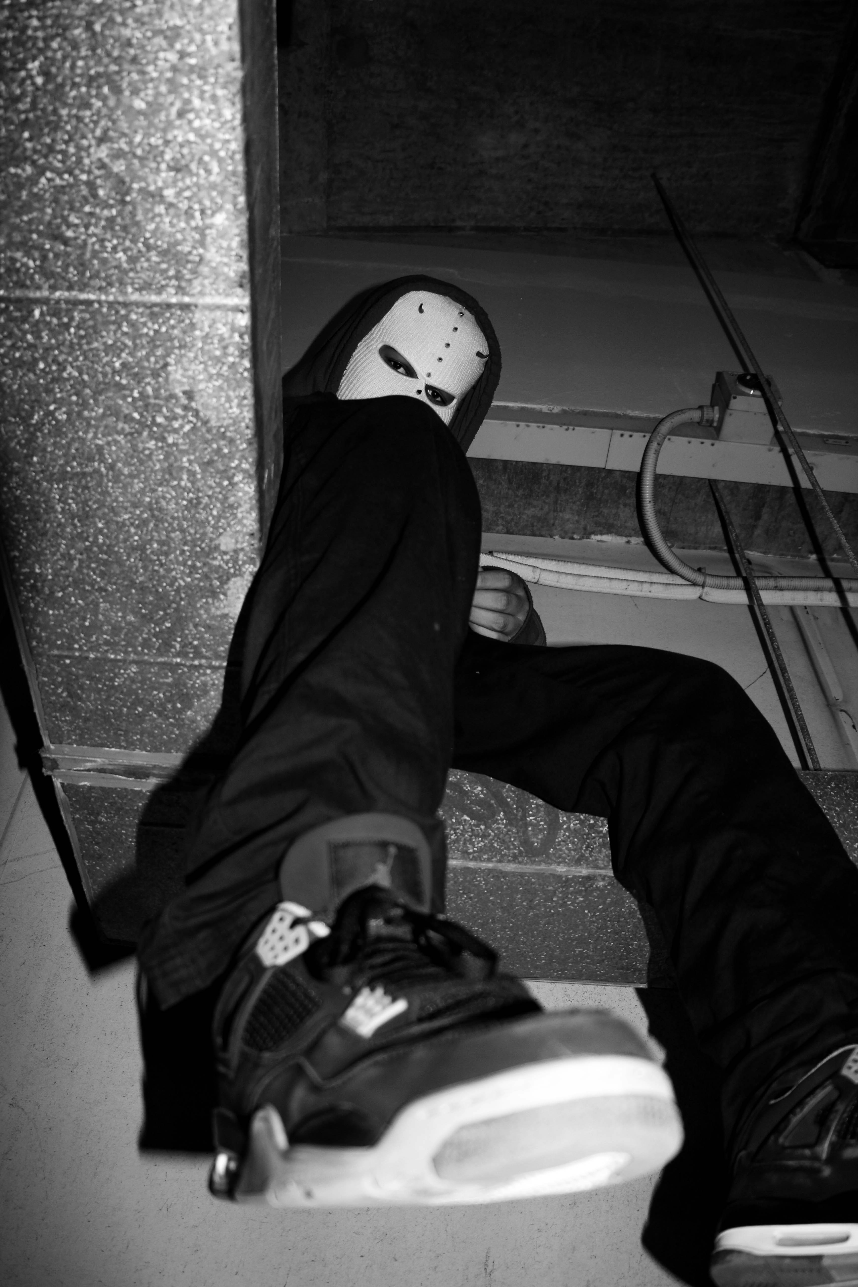 Low-angle Gaze: A Masked Figure on a Rooftop Edge