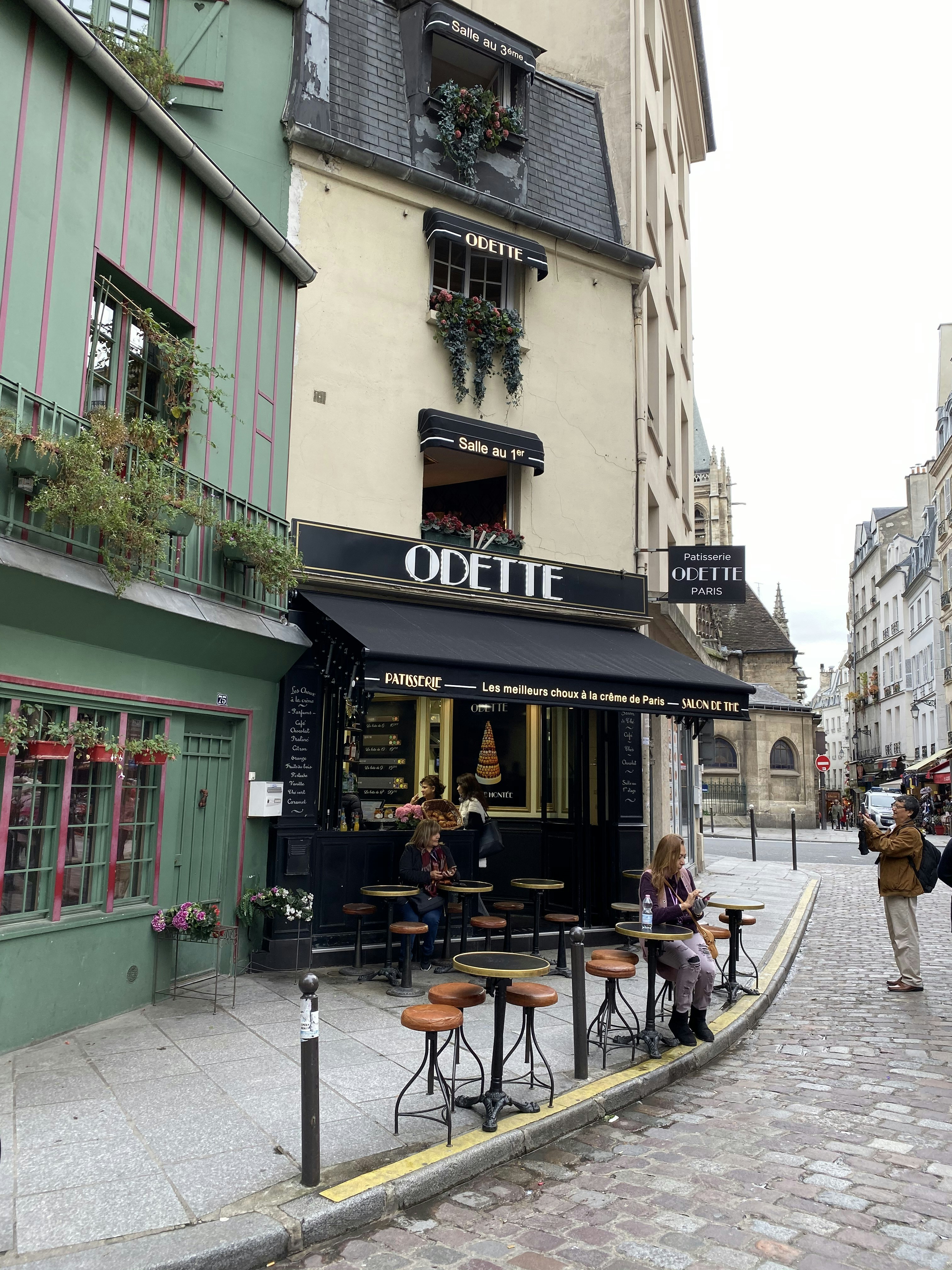 Odette Café on a Cobblestone Rue: Parisian Quiet Amid Colorful Facades