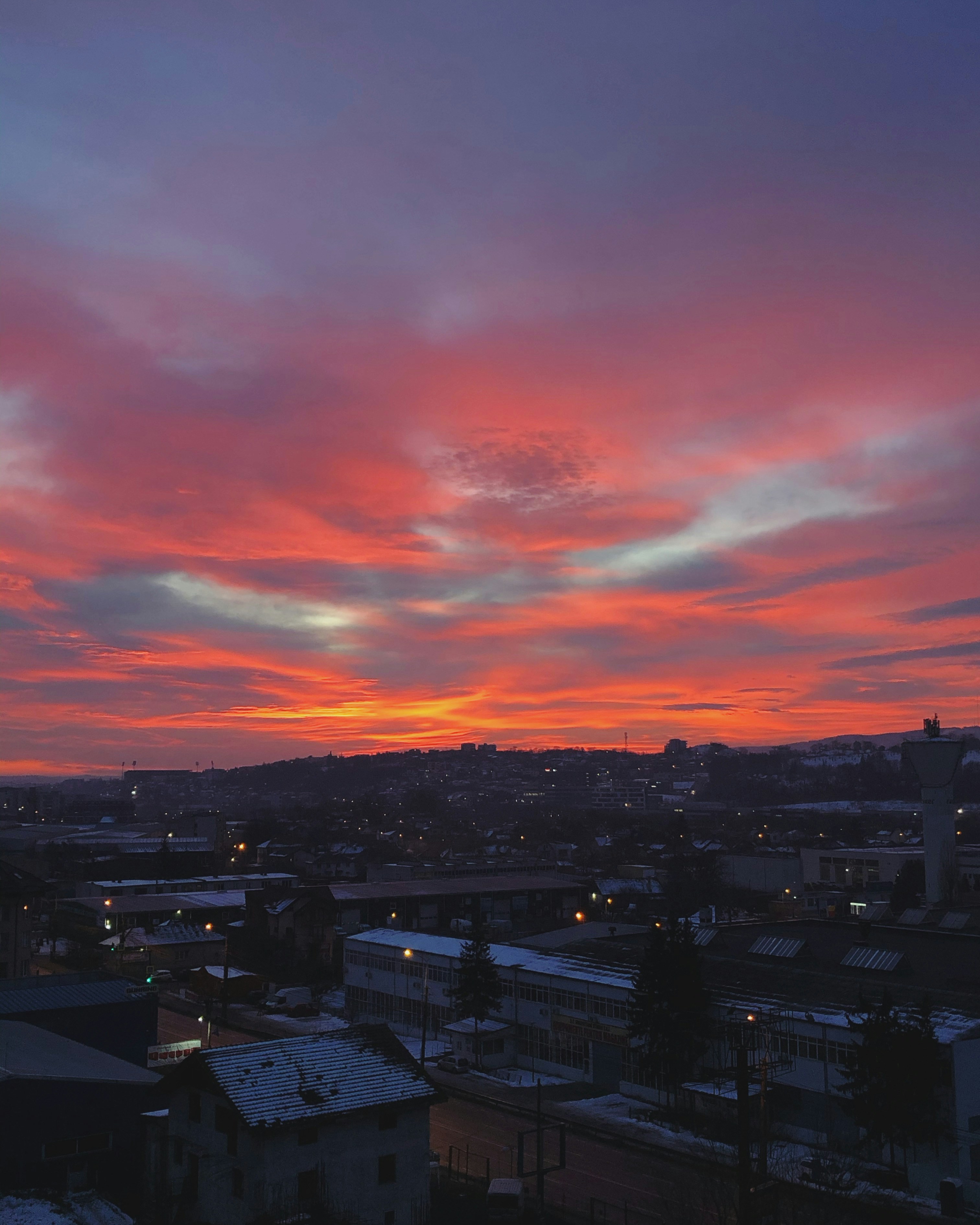 What i see from my window! 😍 No filters added | city with high rise buildings under orange and gray cloudy sky during sunset