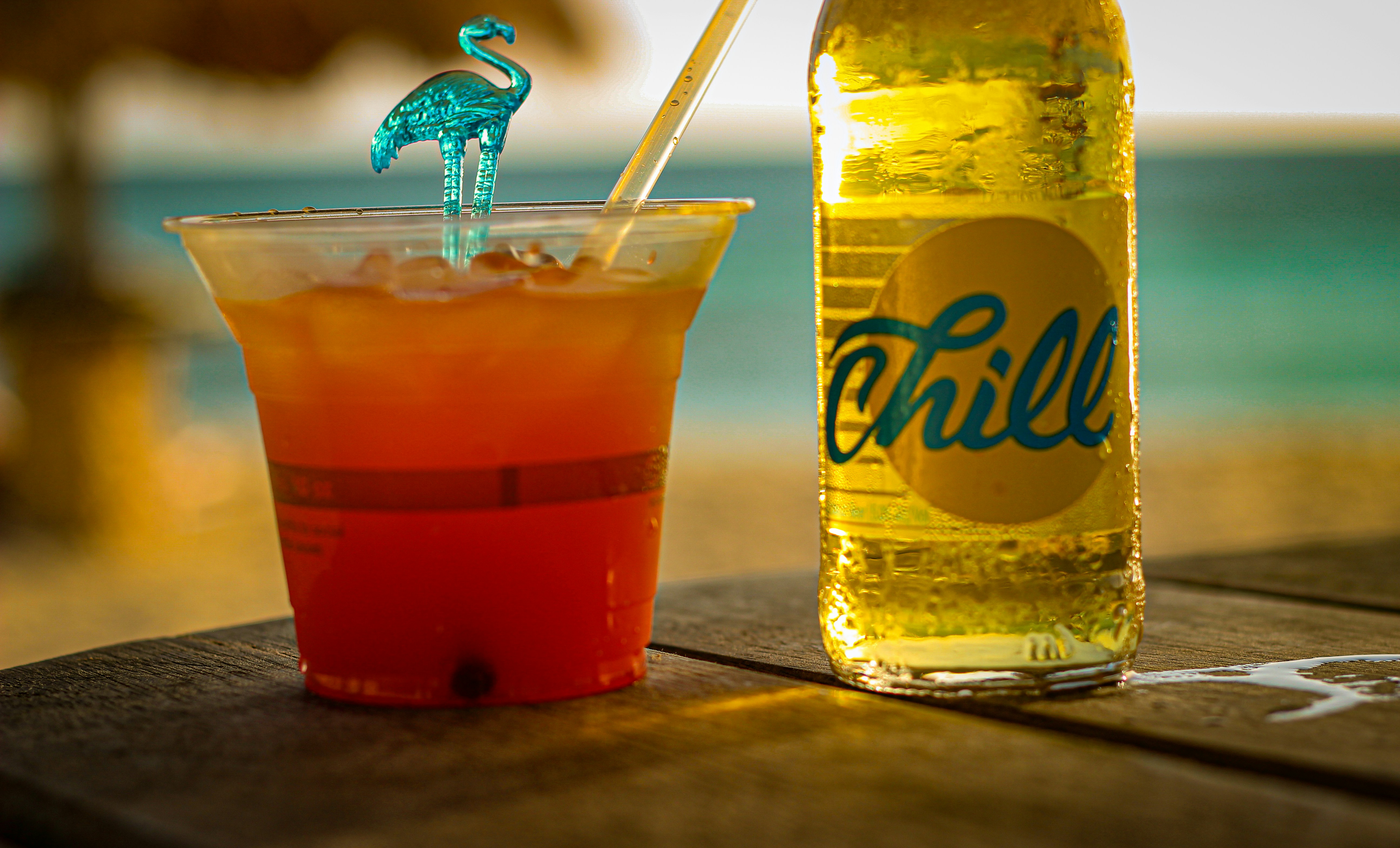 Sunlit Splash: A Tropical Drink and Chill Bottle at the Seaside Deck
