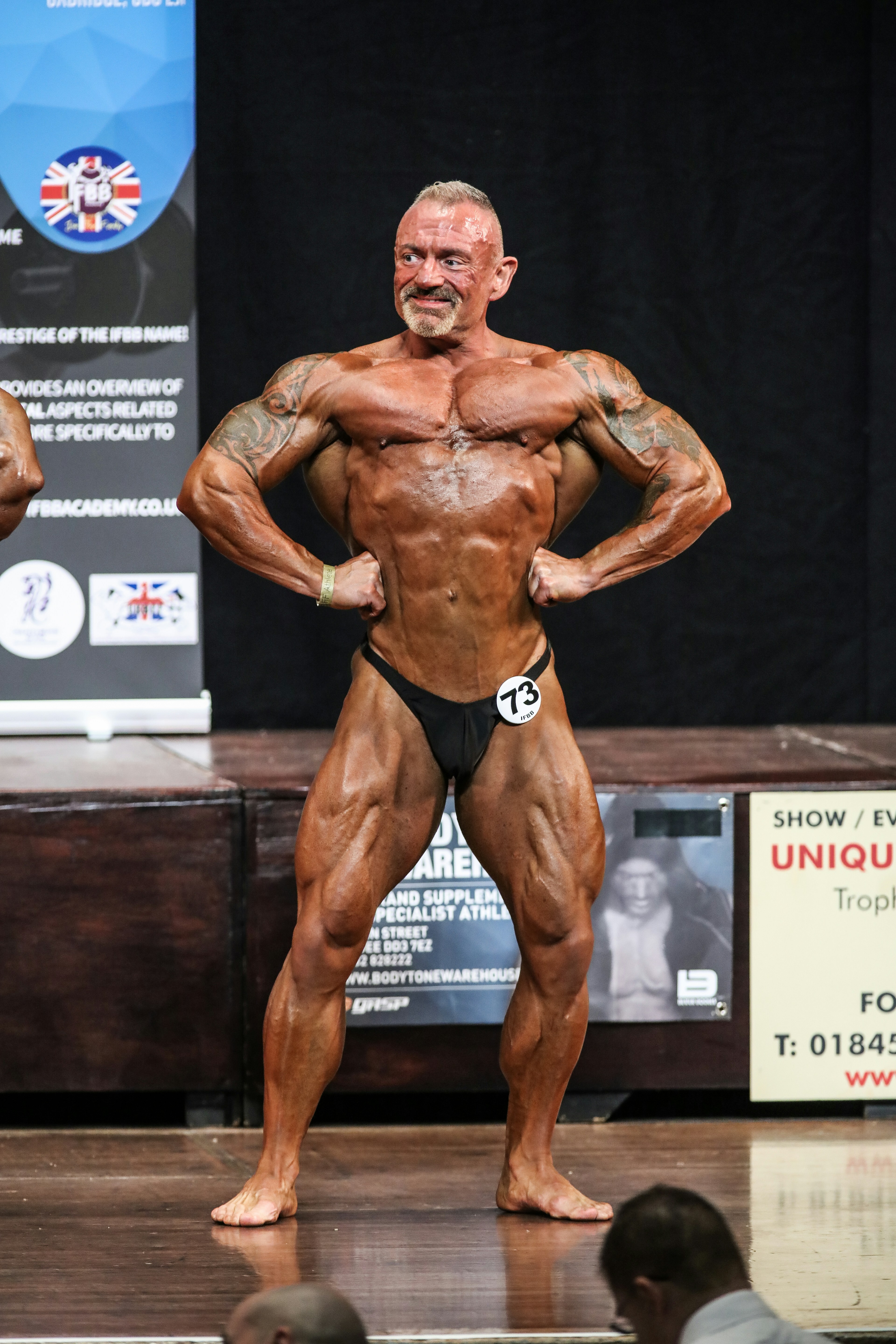 A man standing on a stage with his hands on his hips photo – Free ...