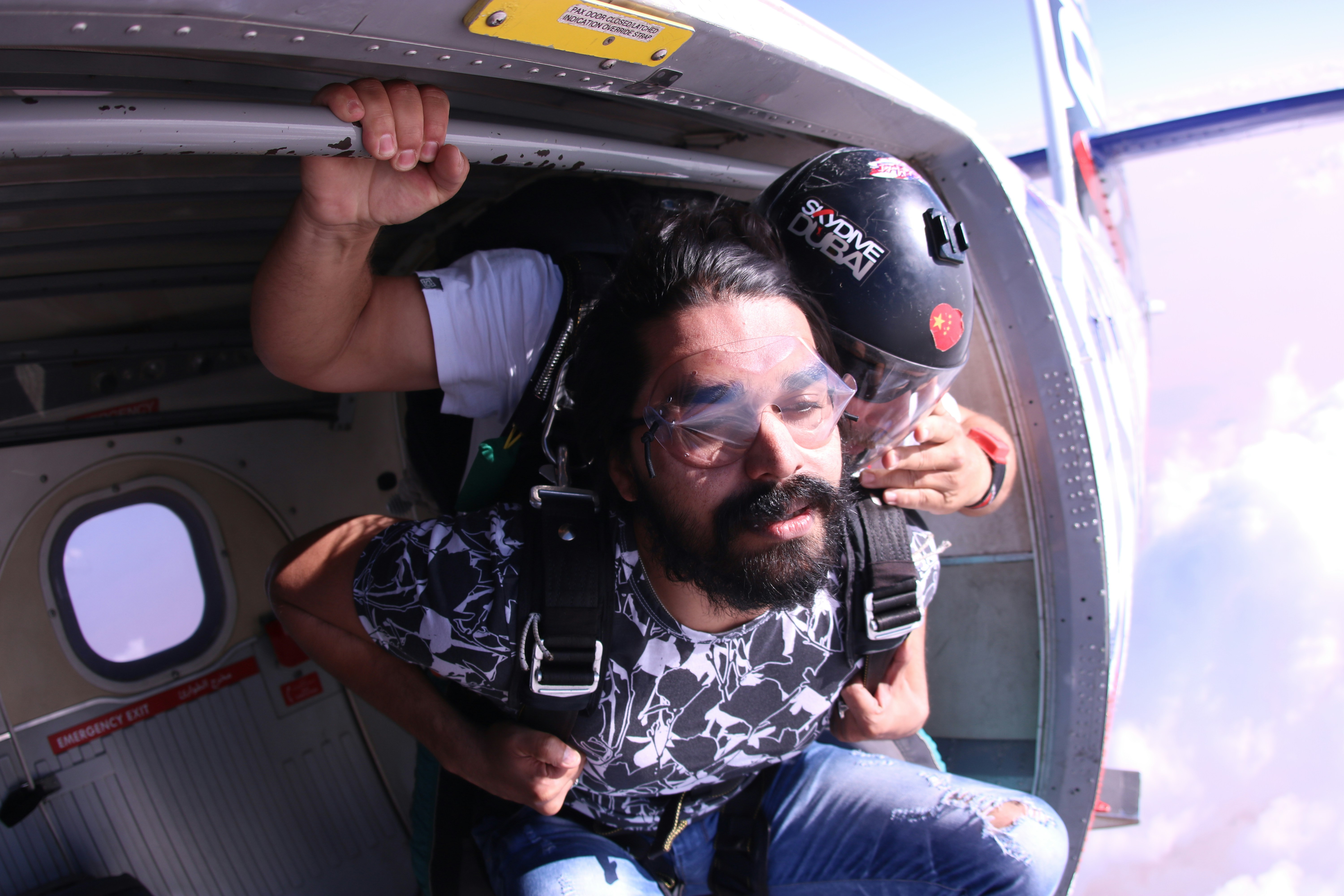 First Leap: A Tandem Skydiver Emerges from the Aircraft Door