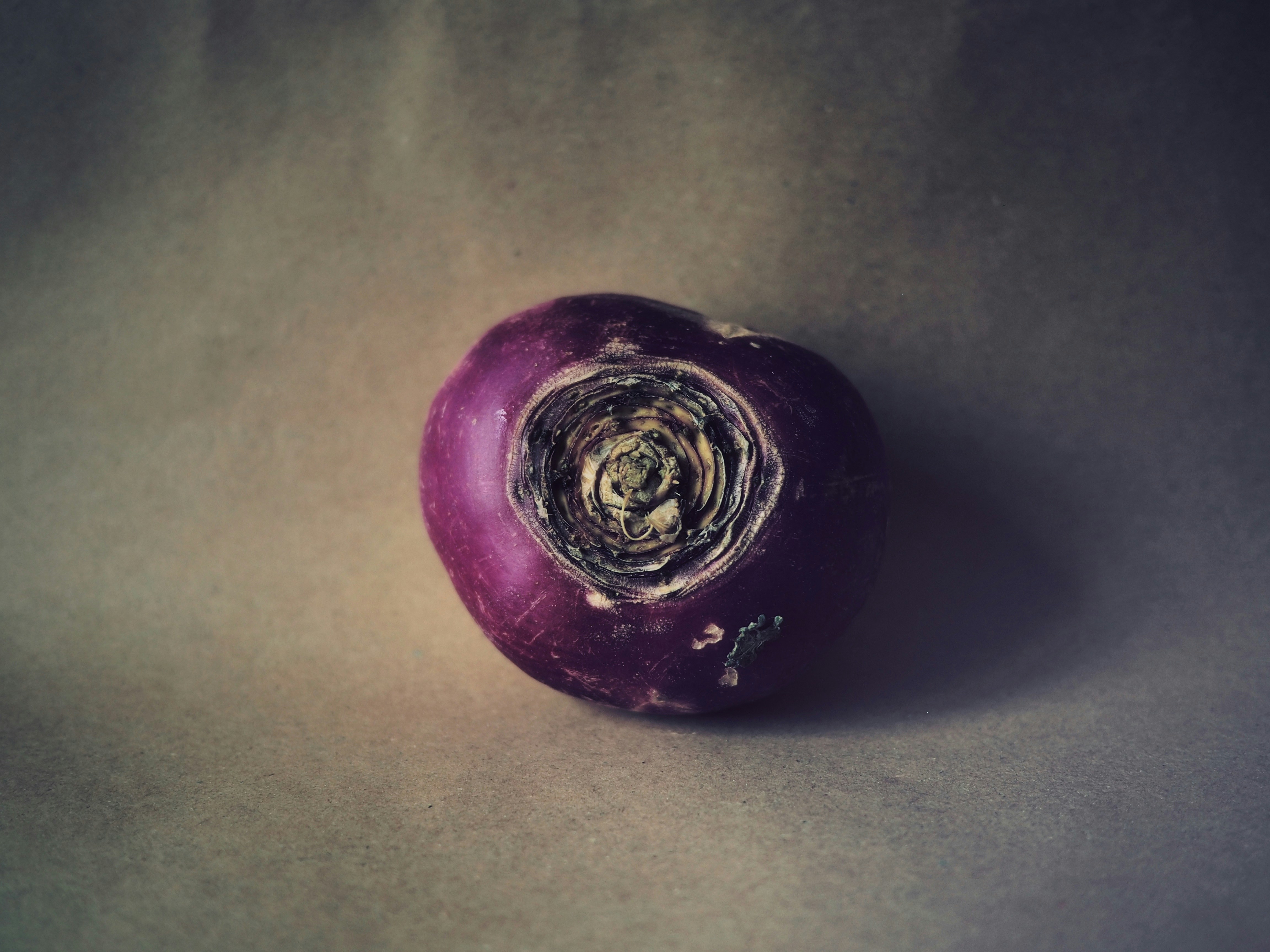 Close-up of a turnip showcasing its intricate inner layers against a soft, neutral backdrop.