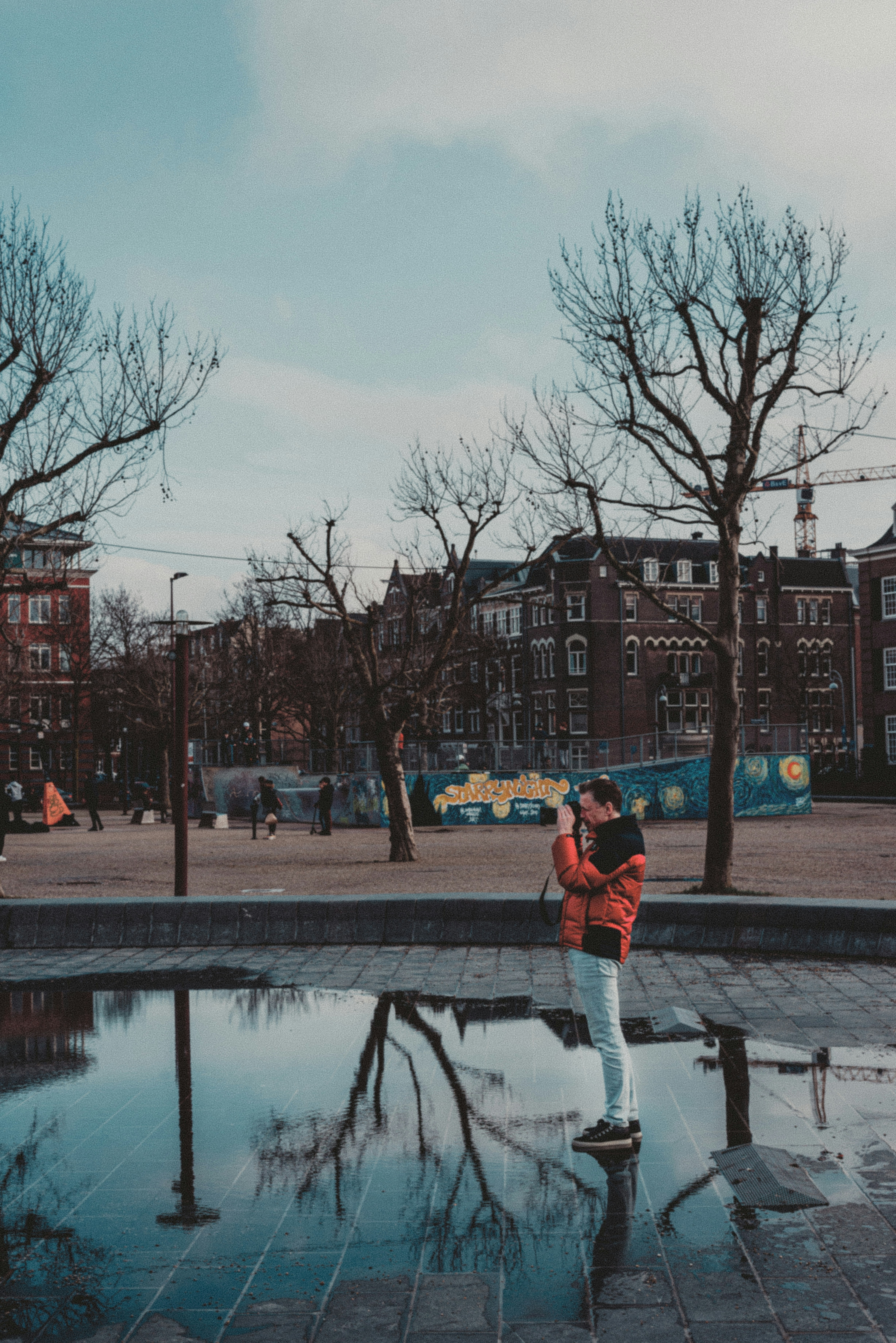 Red Jacket at the Glassy Square: A Quiet City Portrait by the Reflective Pool