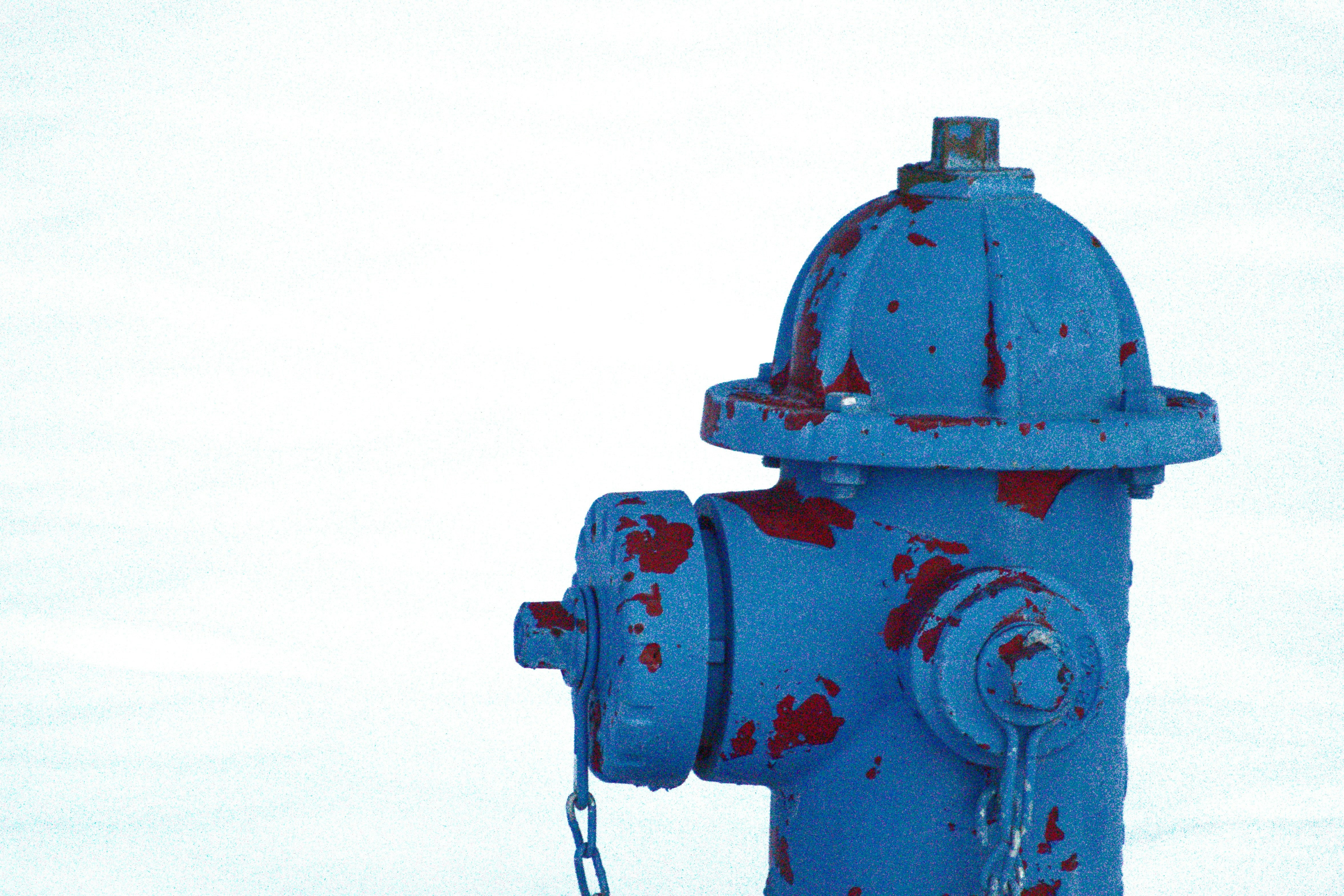 Blue Sentinel: Weathered hydrant in a silent snowfield
