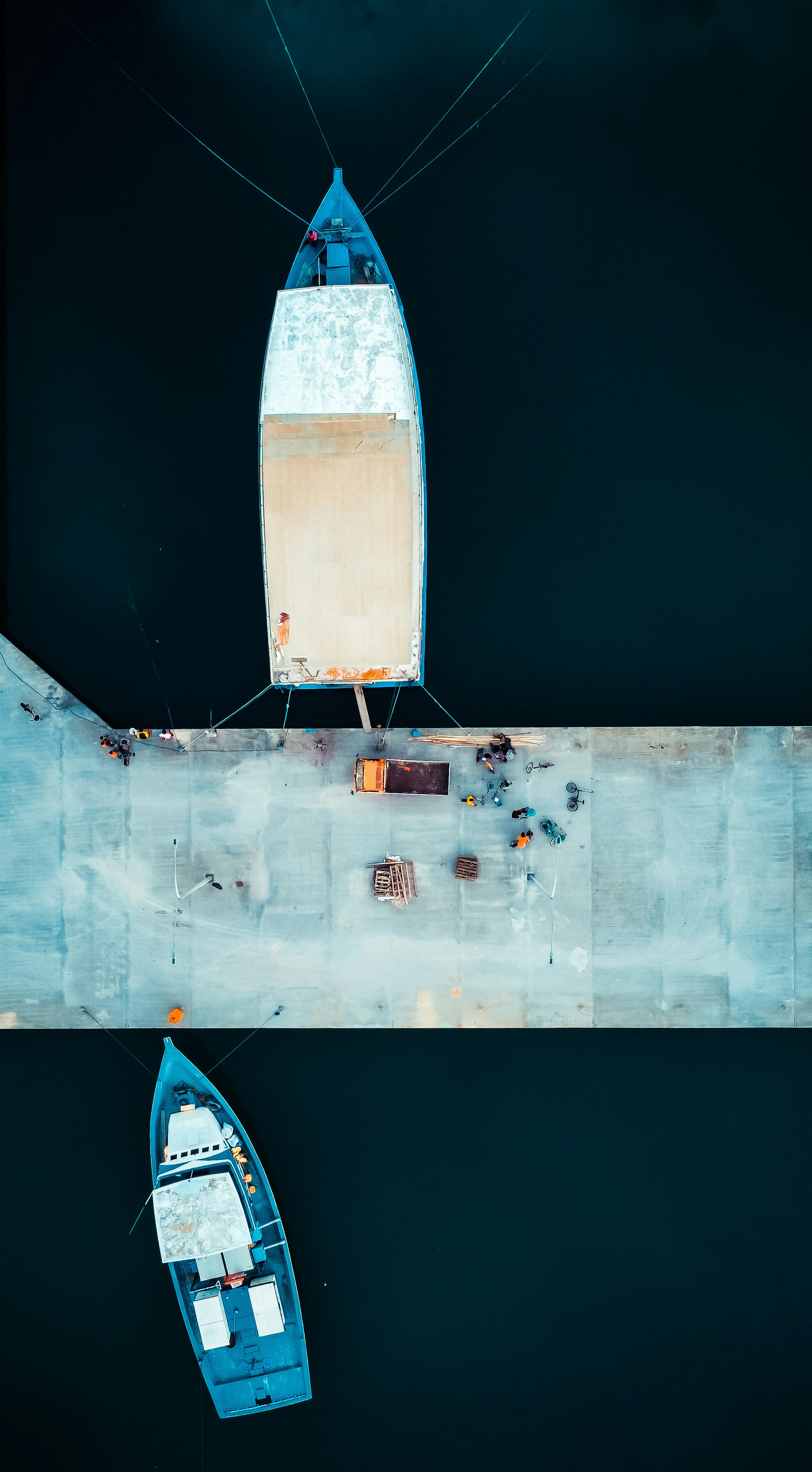 Harbor Geometry: Twin Blue Boats Framed by a Narrow Pier