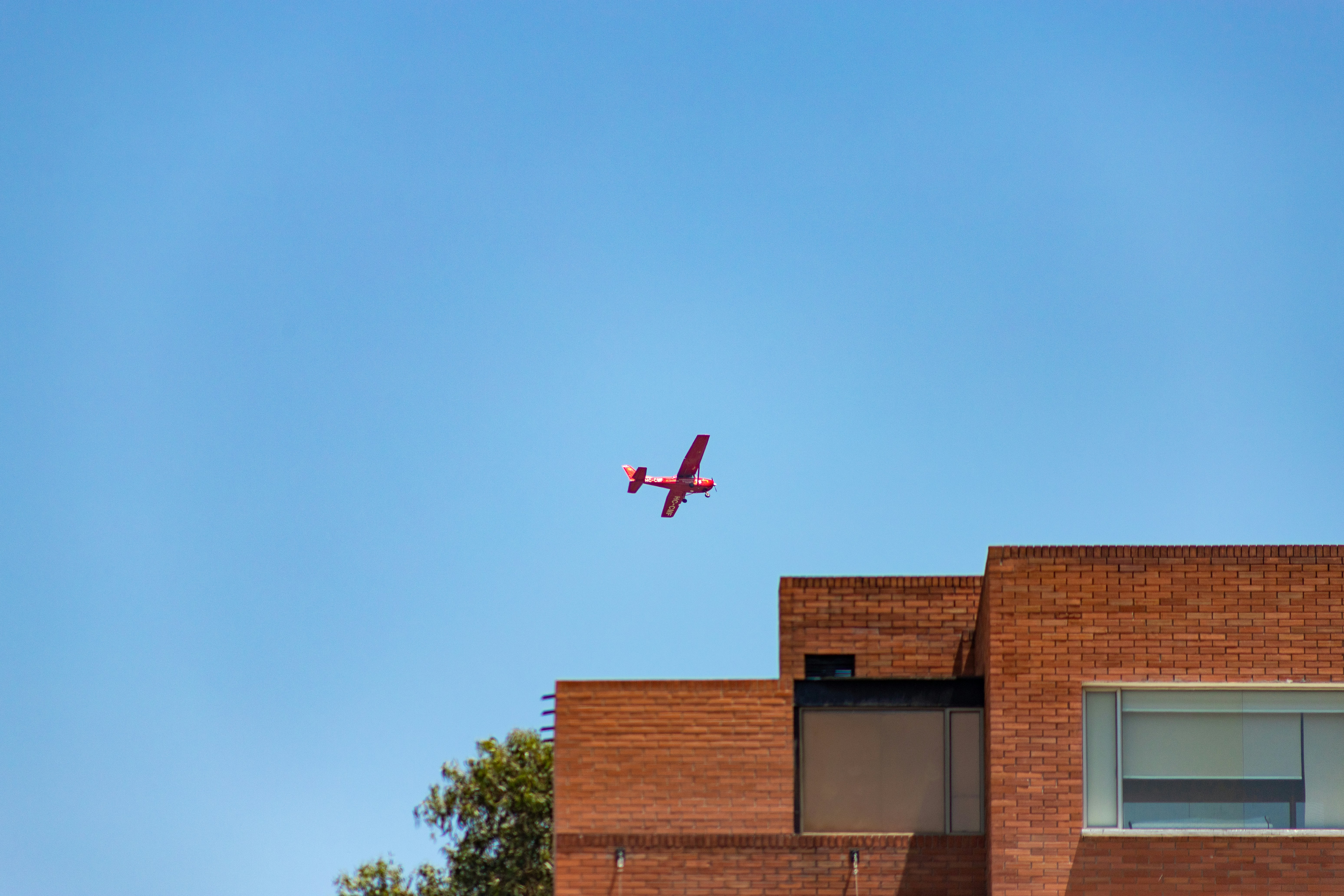 Red Aircraft over Brick Terrace