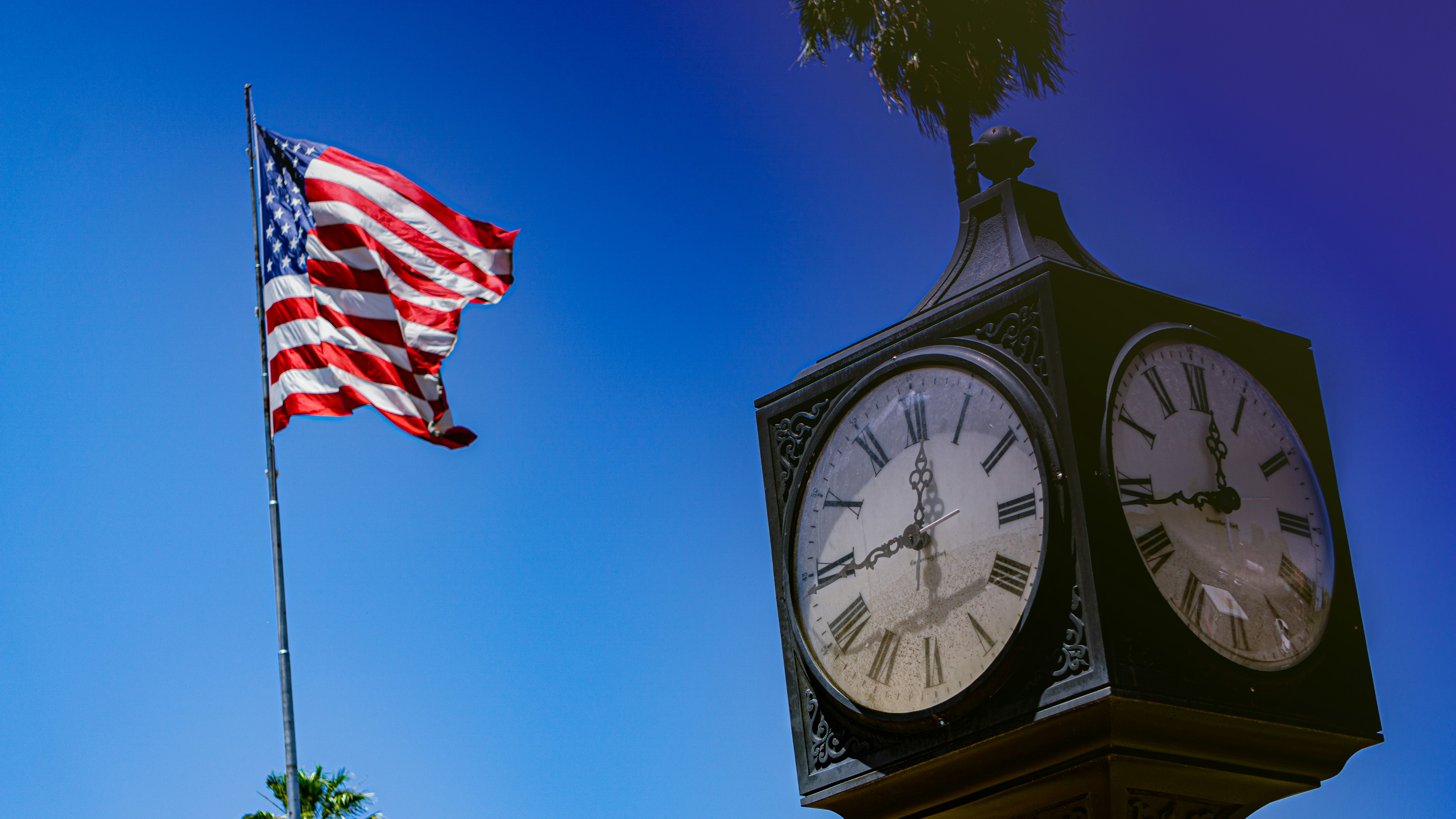 Time on the Square: A Clocktower and a Flag Against a Cobalt Sky