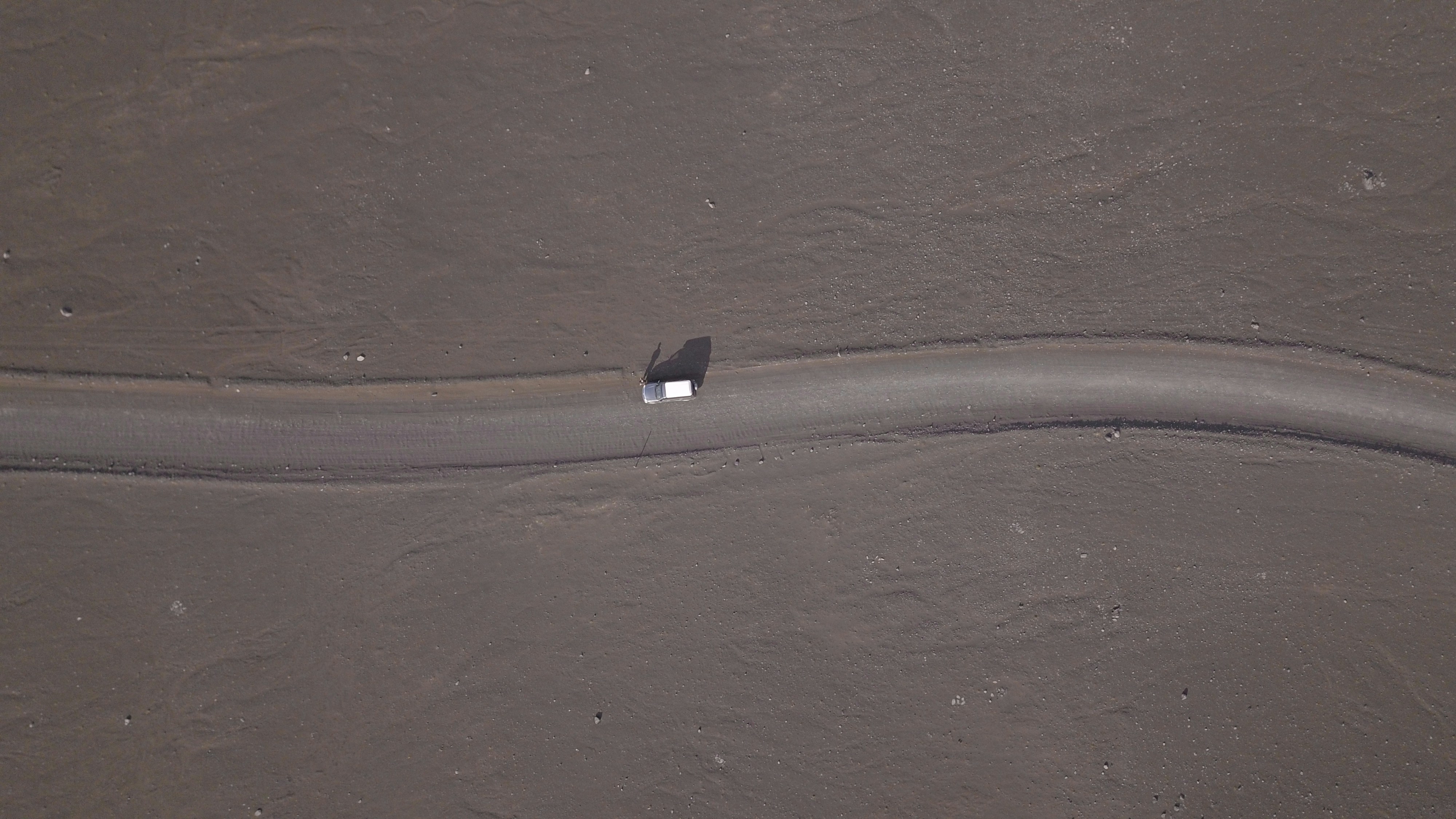 Solitary White Marker on a Winding Desert Road