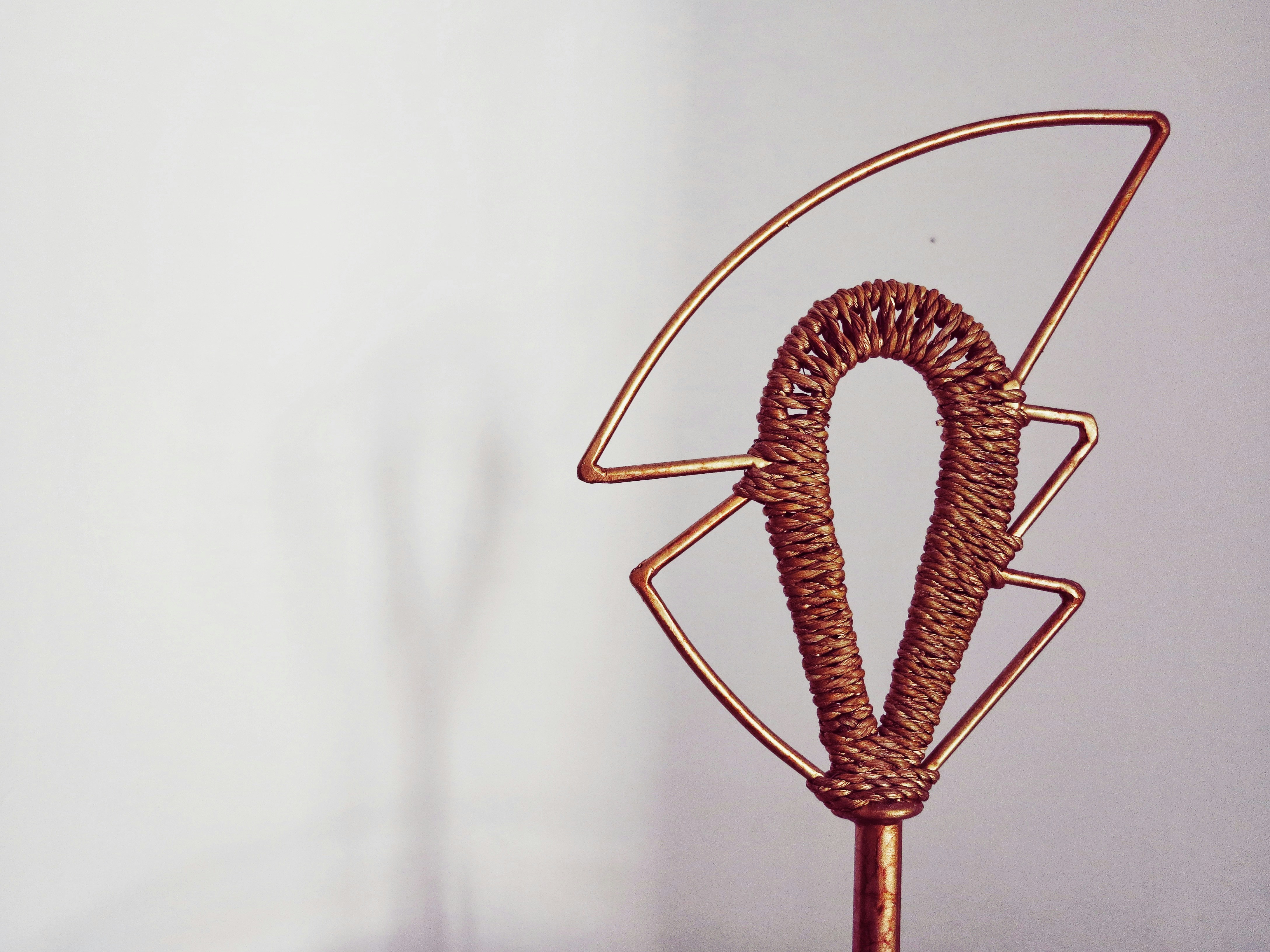Copper-wire scavenger: a stylized heart‑shaped sculpture rising from a geometric frame