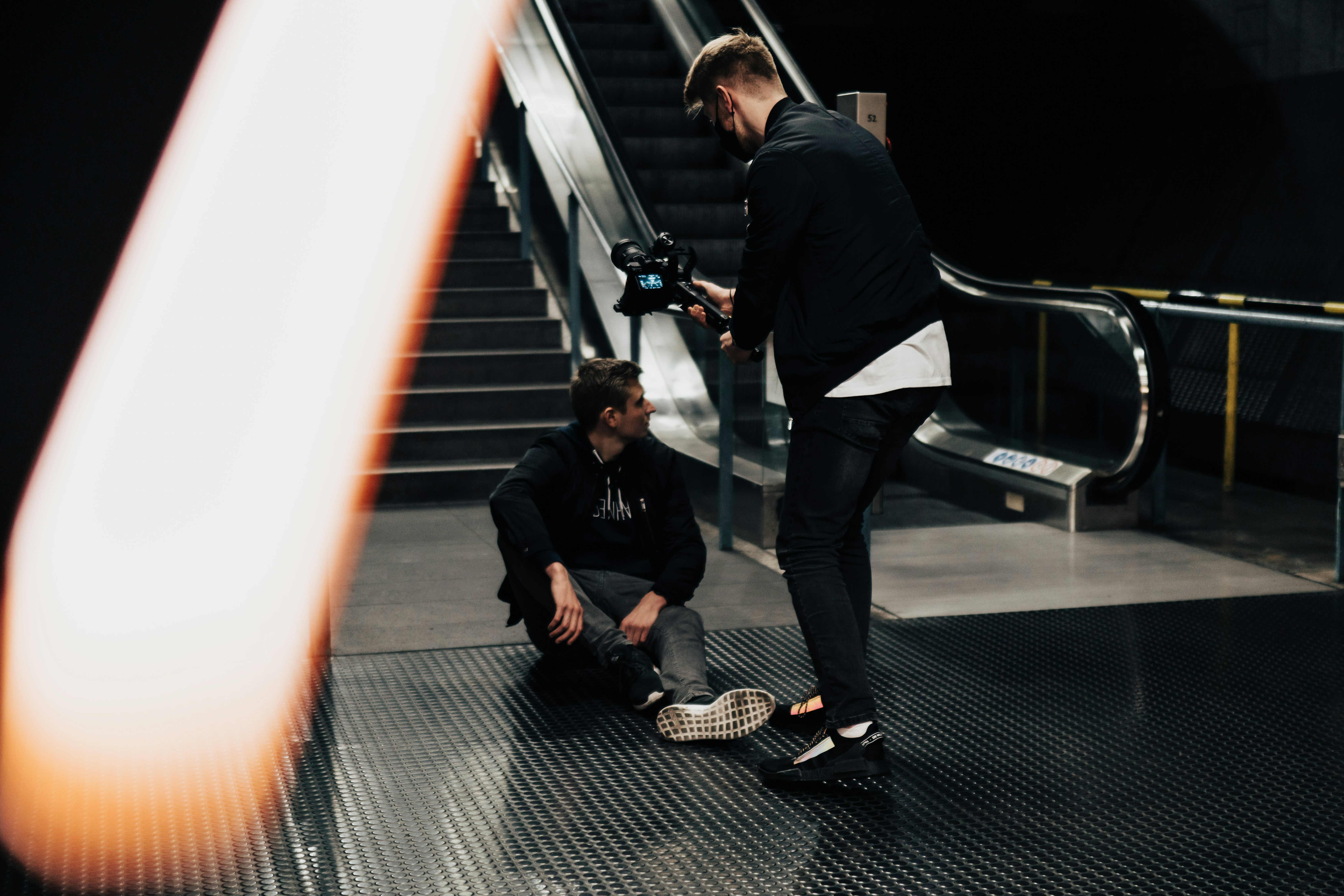 Two-Tier Moment: A Crouched Moment Captured Under Neon Rail Light