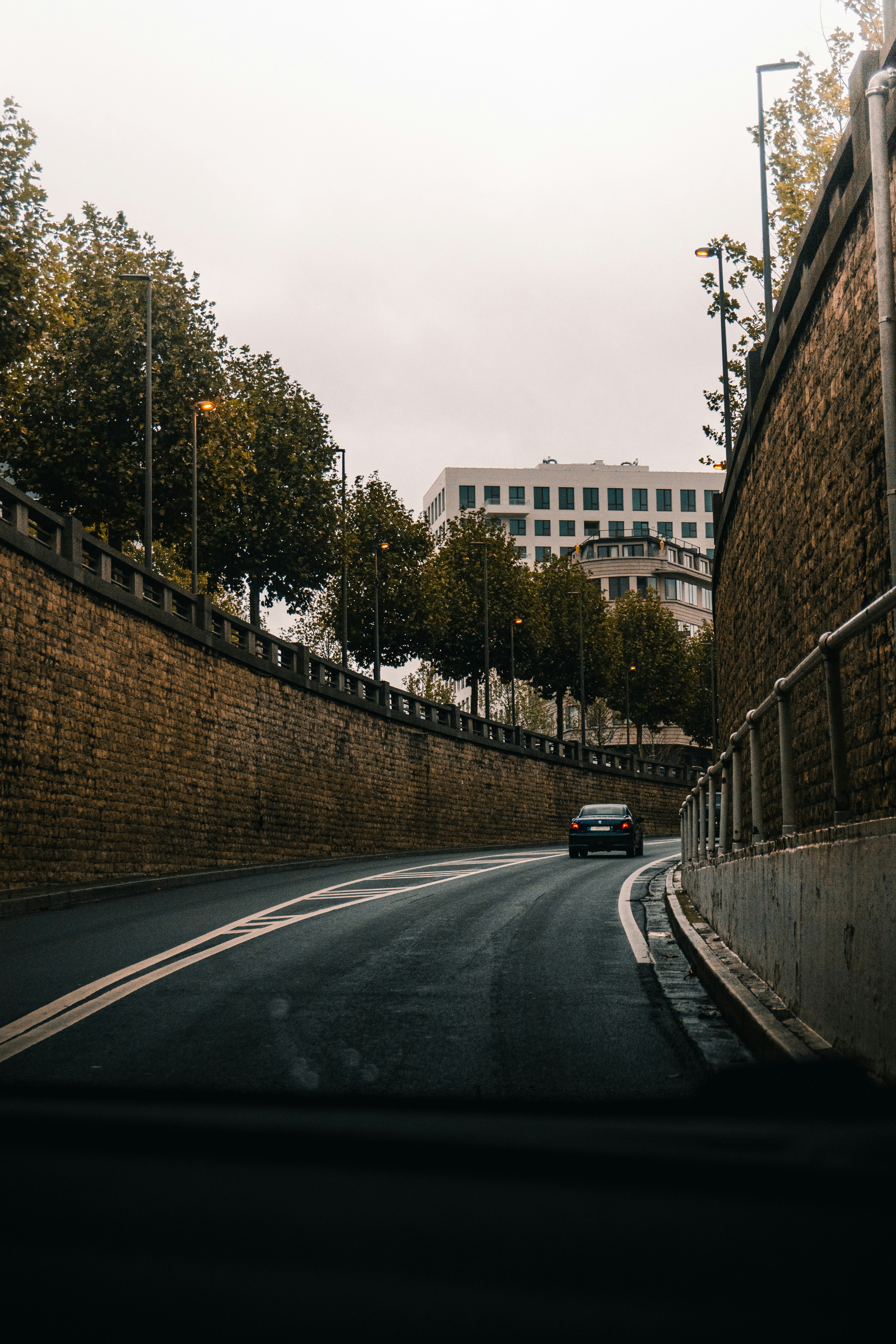 Curved Descent Through a Brick-Walled Street at Dusk