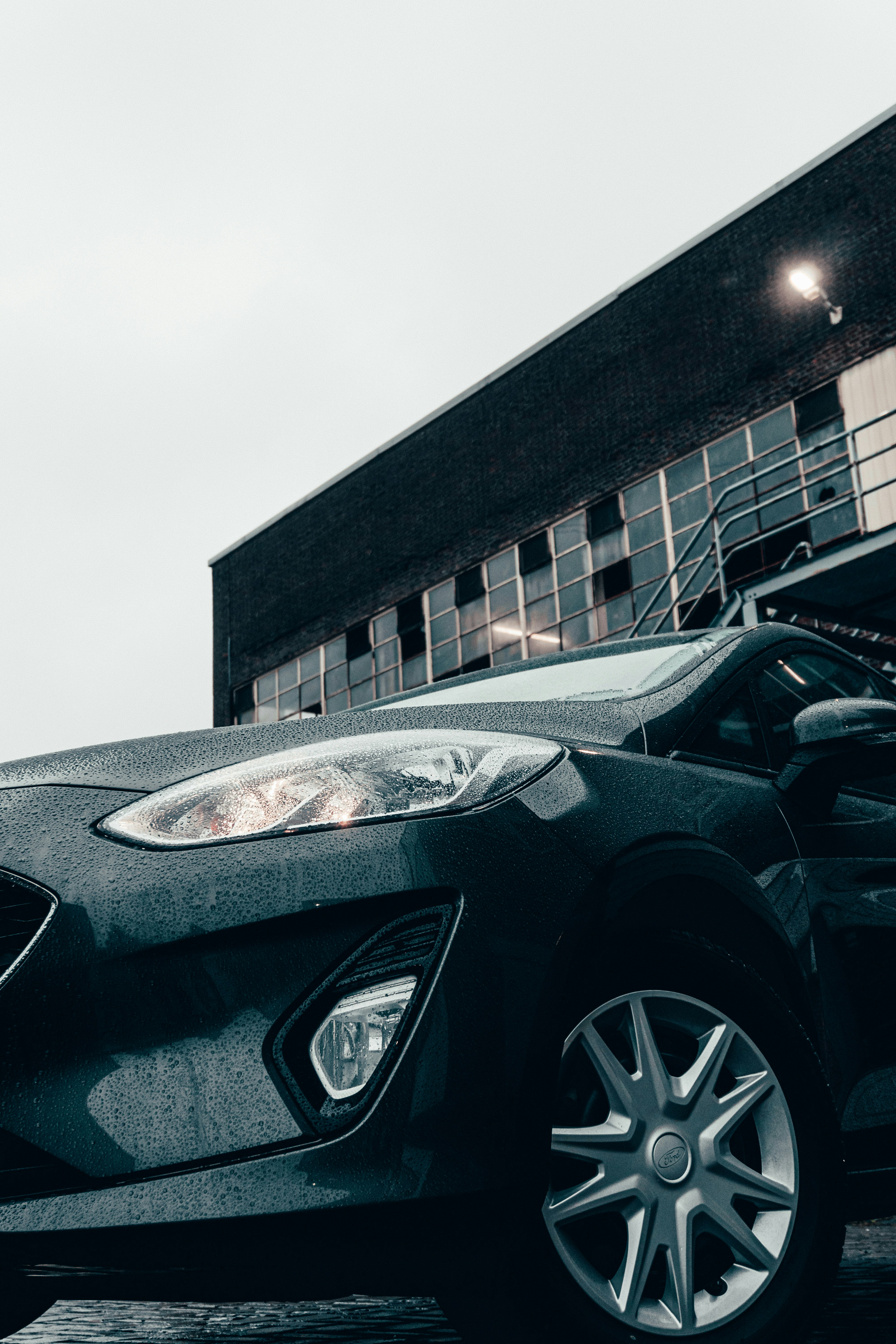 Rain-Kissed Front Quarter Against an Industrial Backdrop