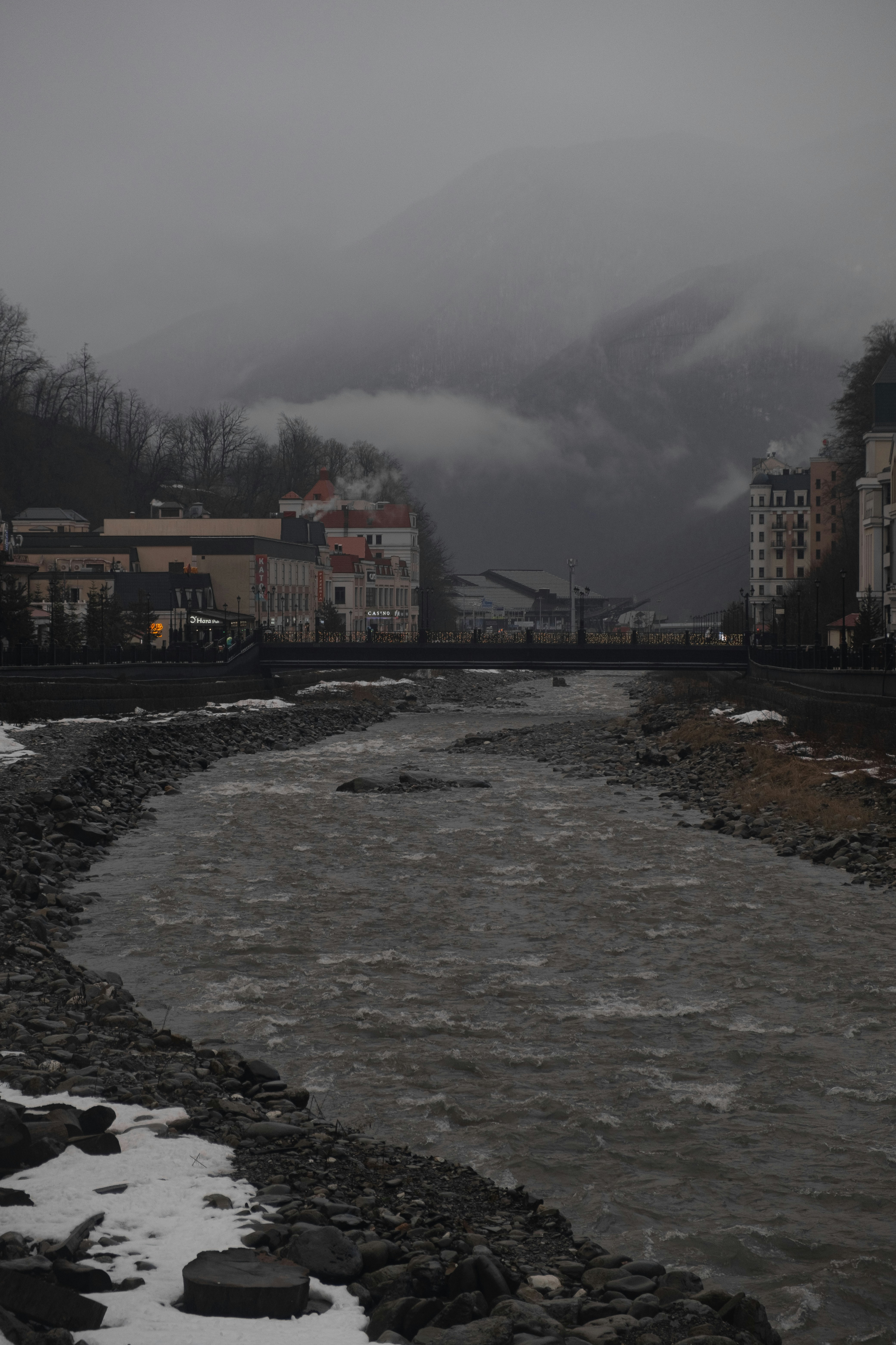 Fogbound Riverfront: A City Quietly Faces Cloud-Sheathed Mountains