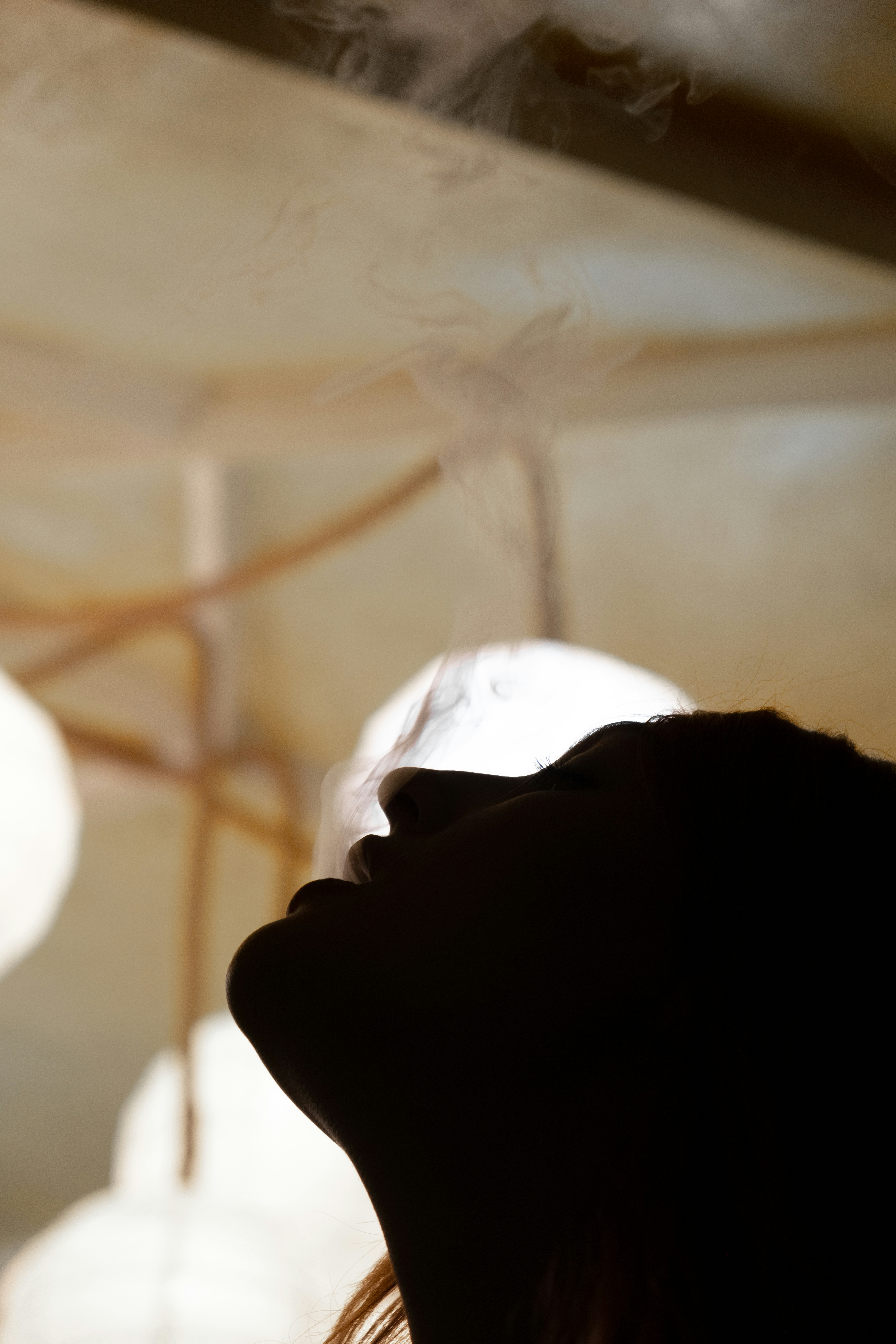 Silhouette Beneath Warm Lantern Orbs