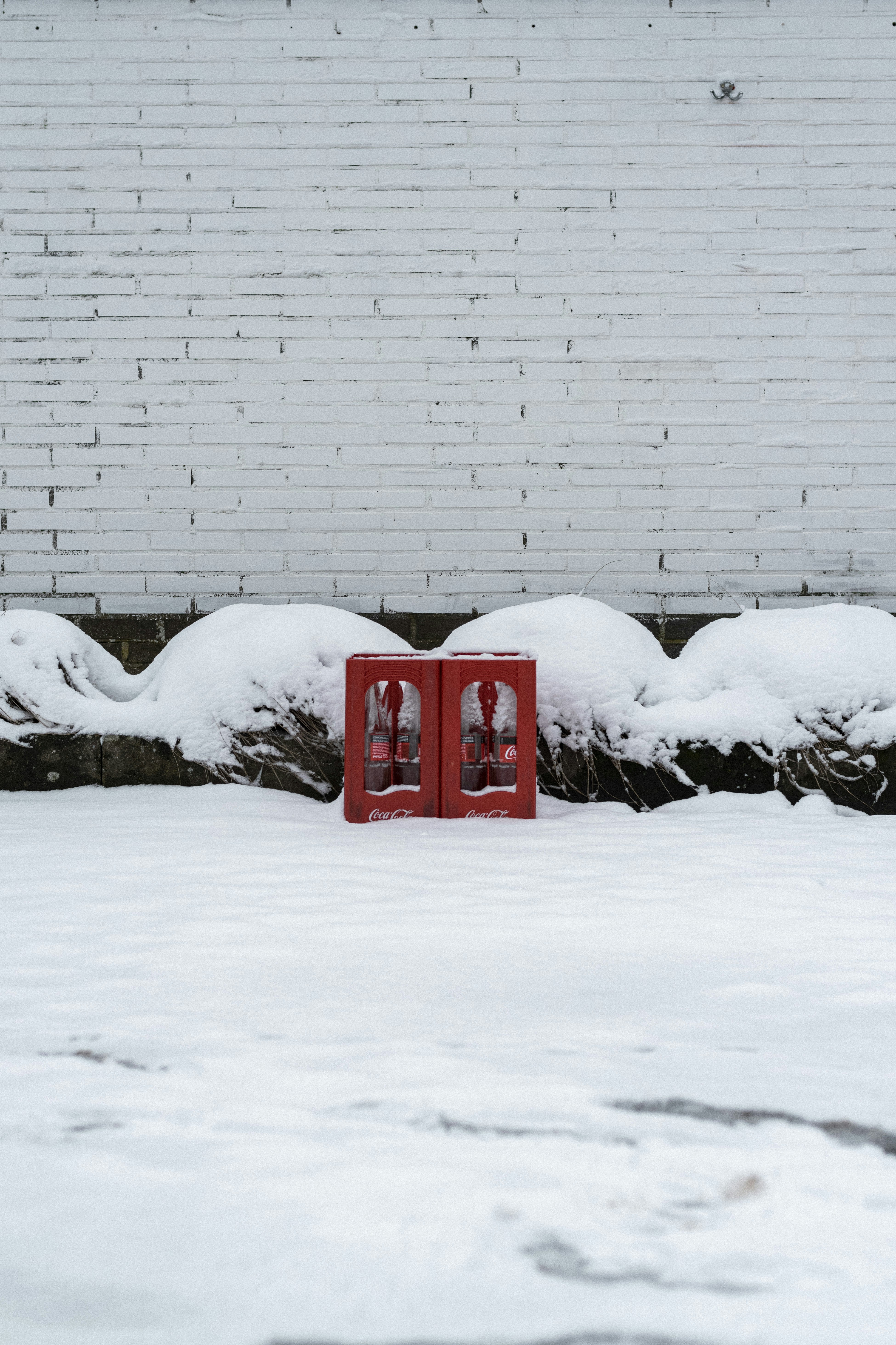 Red Coca-Cola Crates in Snow: A Minimal Still-Life by the White Wall