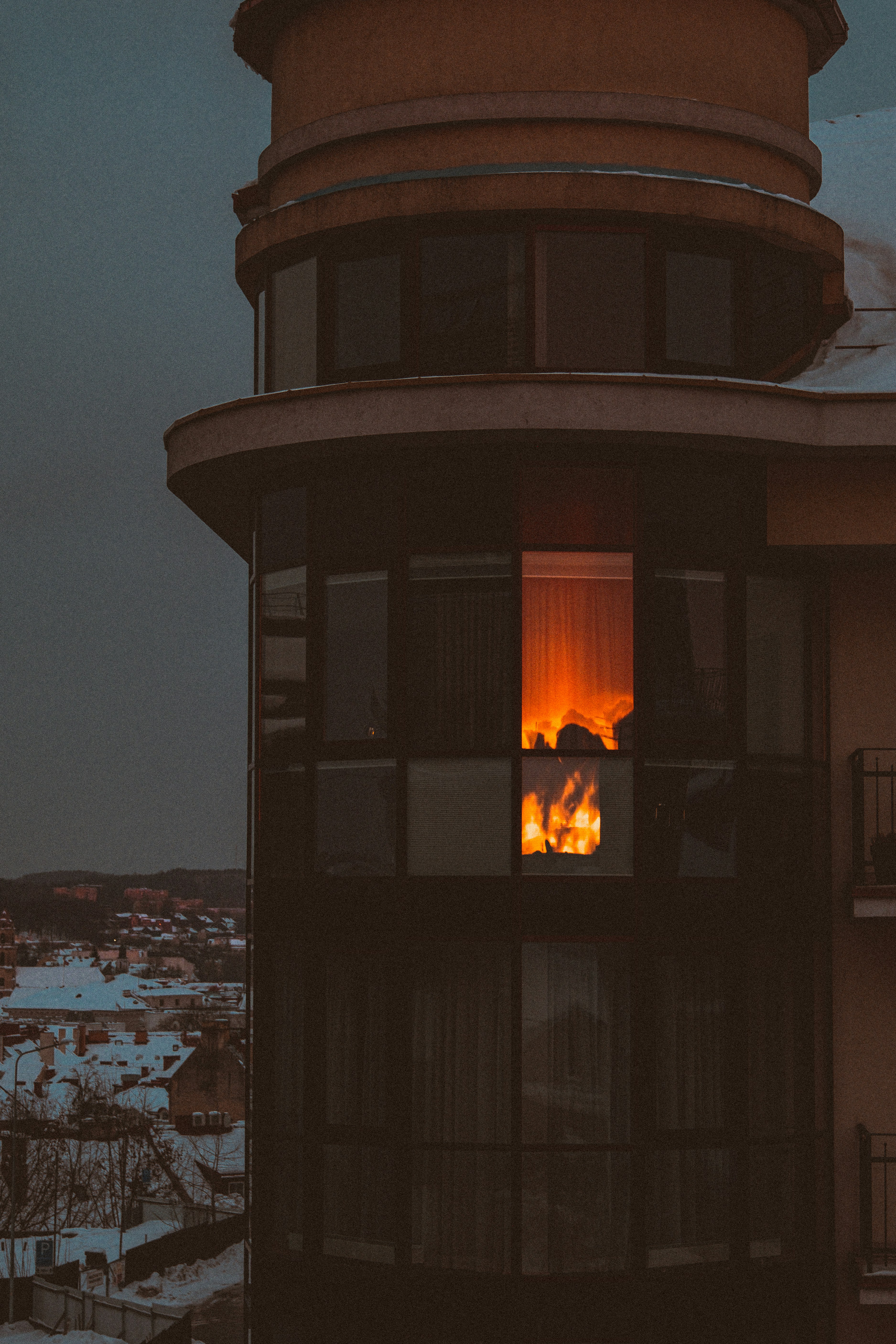 Firelight in a Circular Tower Window at Dusk
