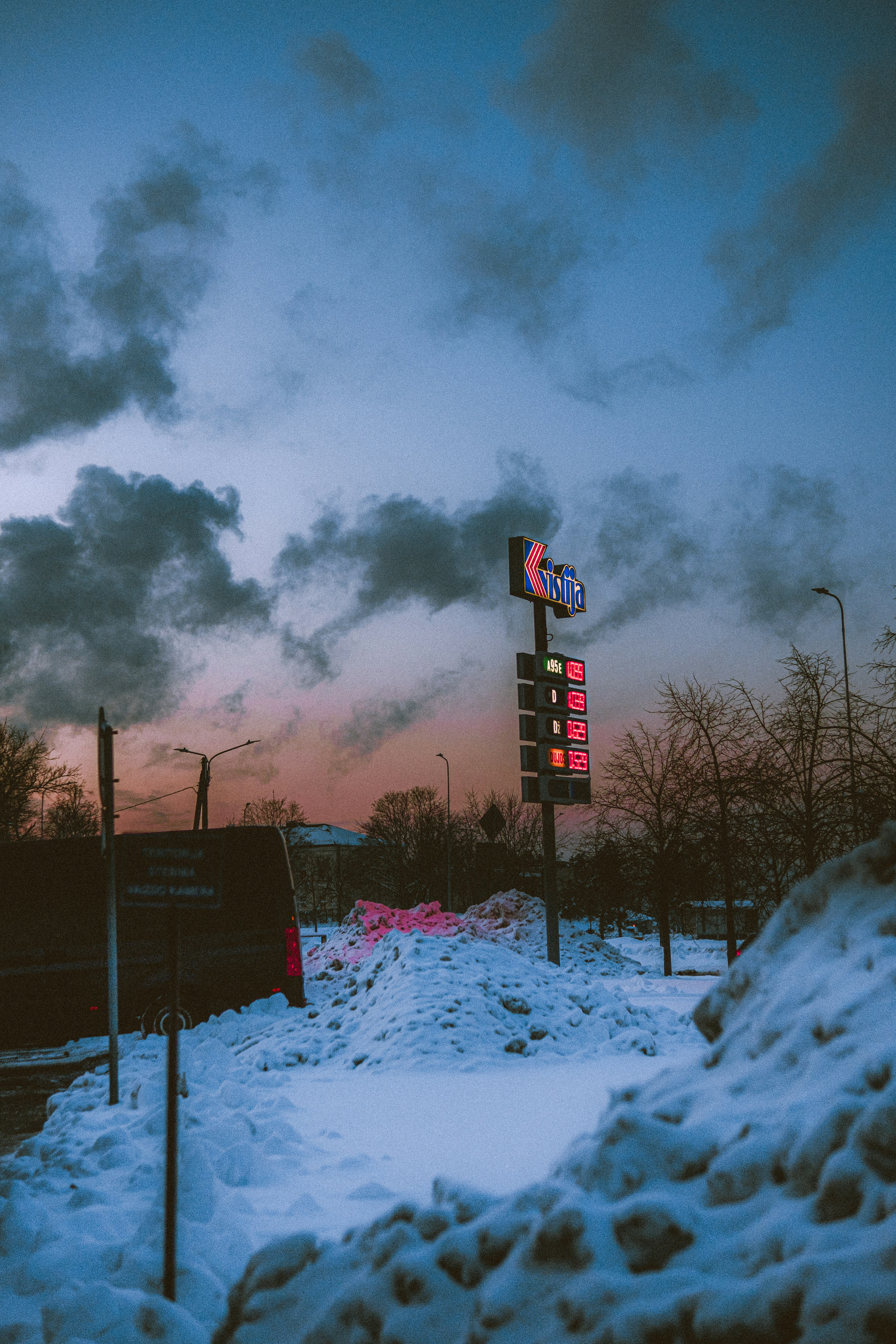 Neon Logo Sign at Dusk Over Snow-Lit Street