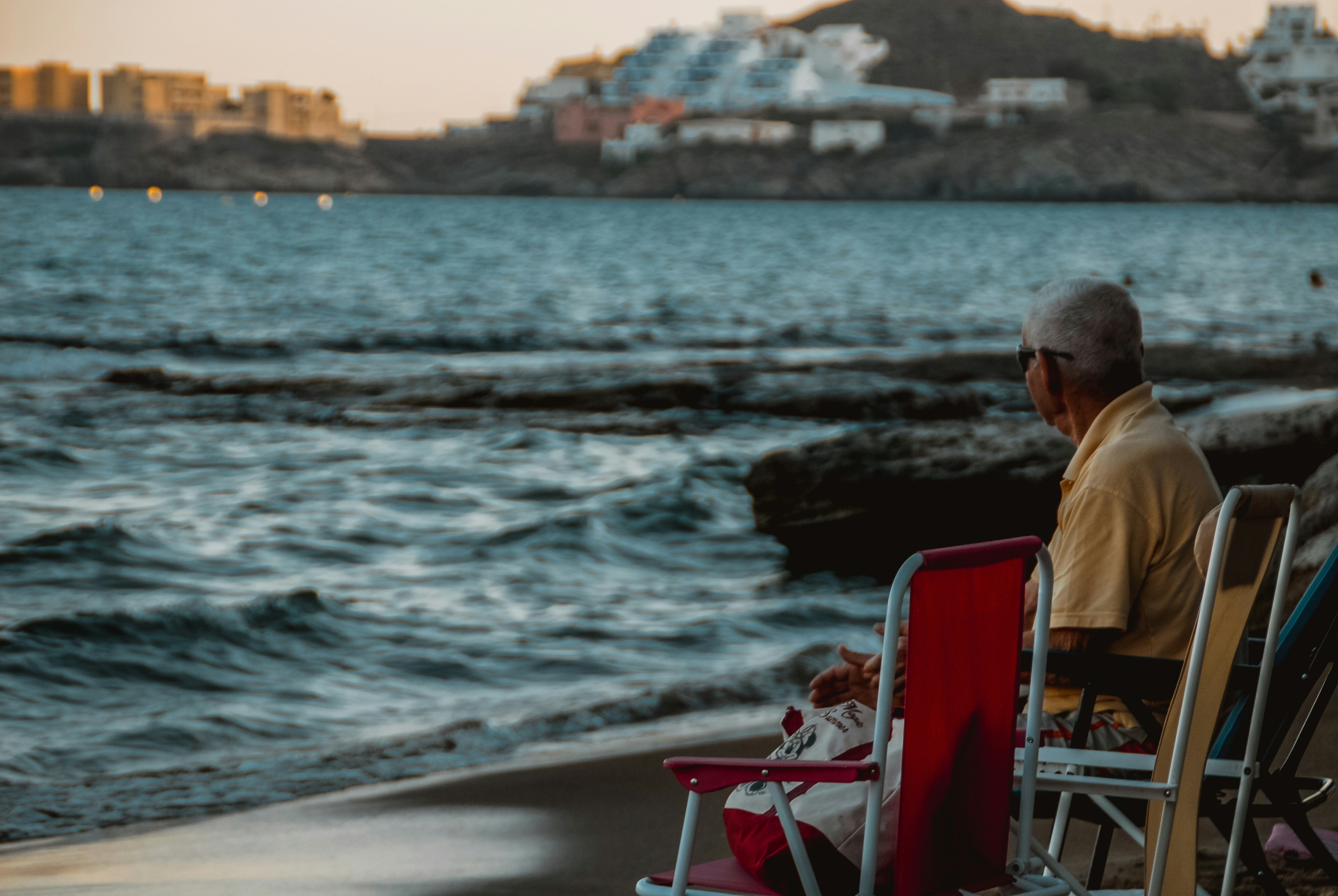 Quiet Seaside Moment: Elderly Man by the Shoreline