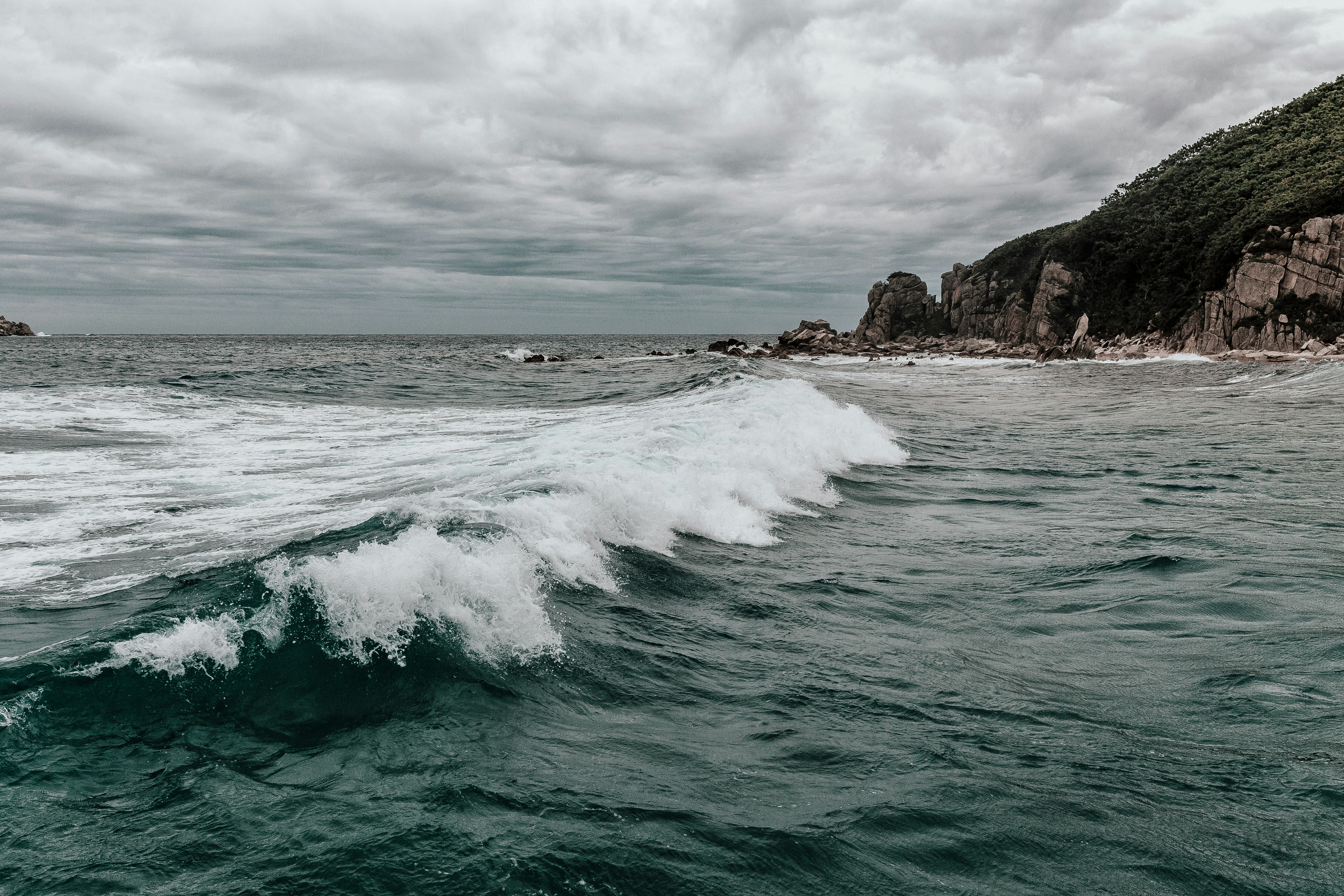 Foam Crest at the Cliffed Coast Under a Brooding Sky