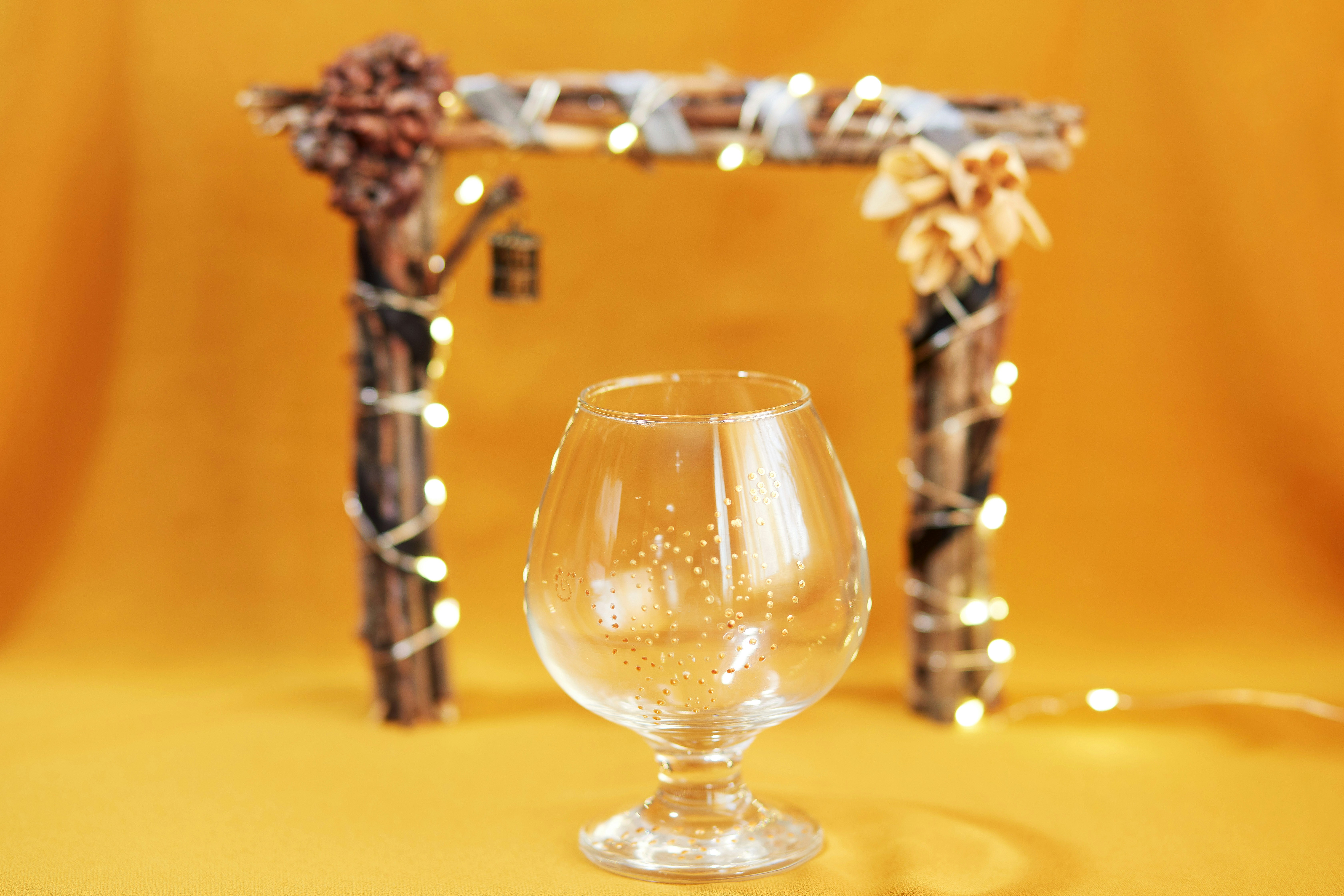 Amber Halo: A Singleton Goblet Beneath a Fairy-Lit Arch