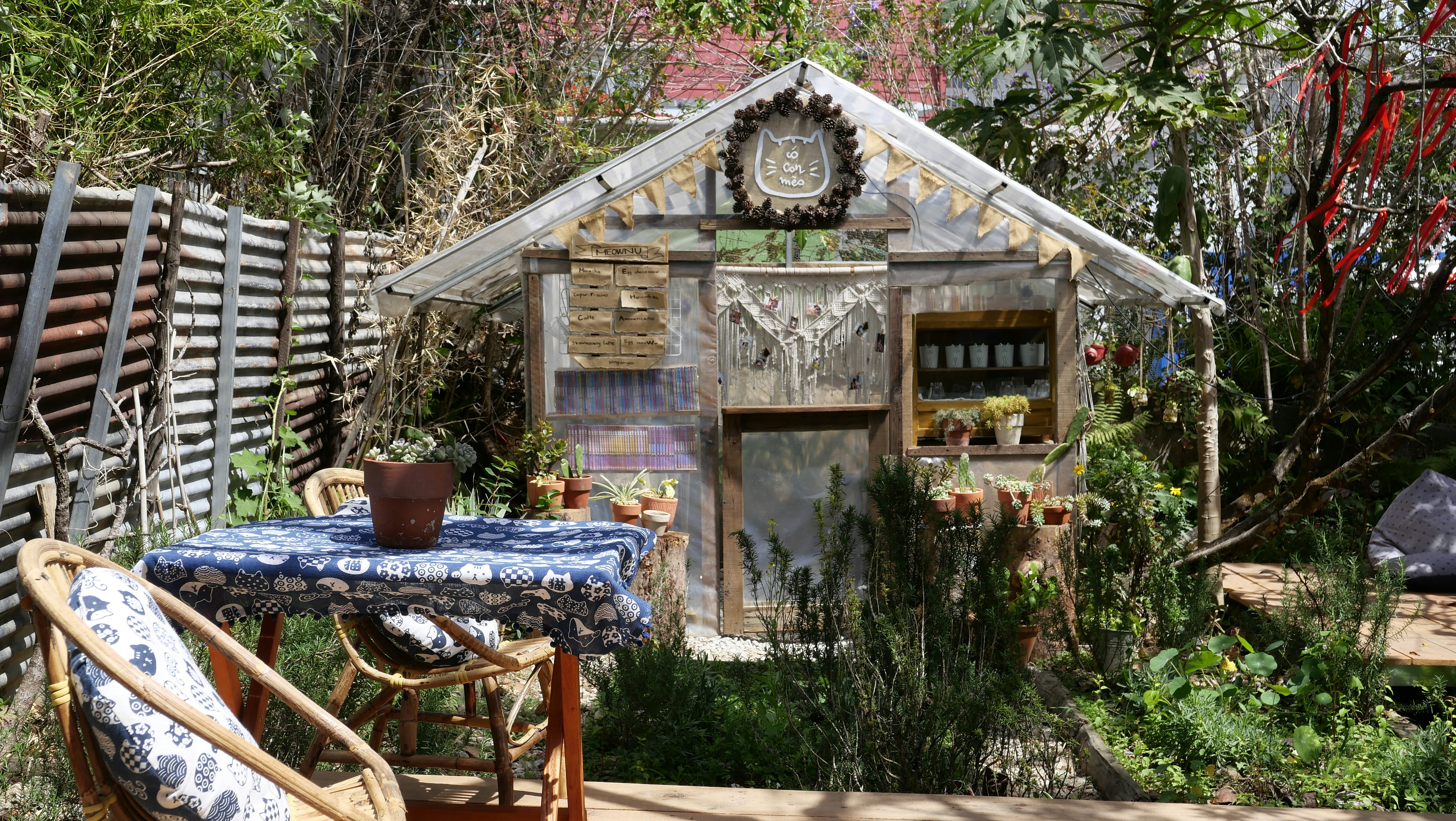 Charming garden shed adorned with eclectic decorations, surrounded by lush greenery and a cozy seating area.
