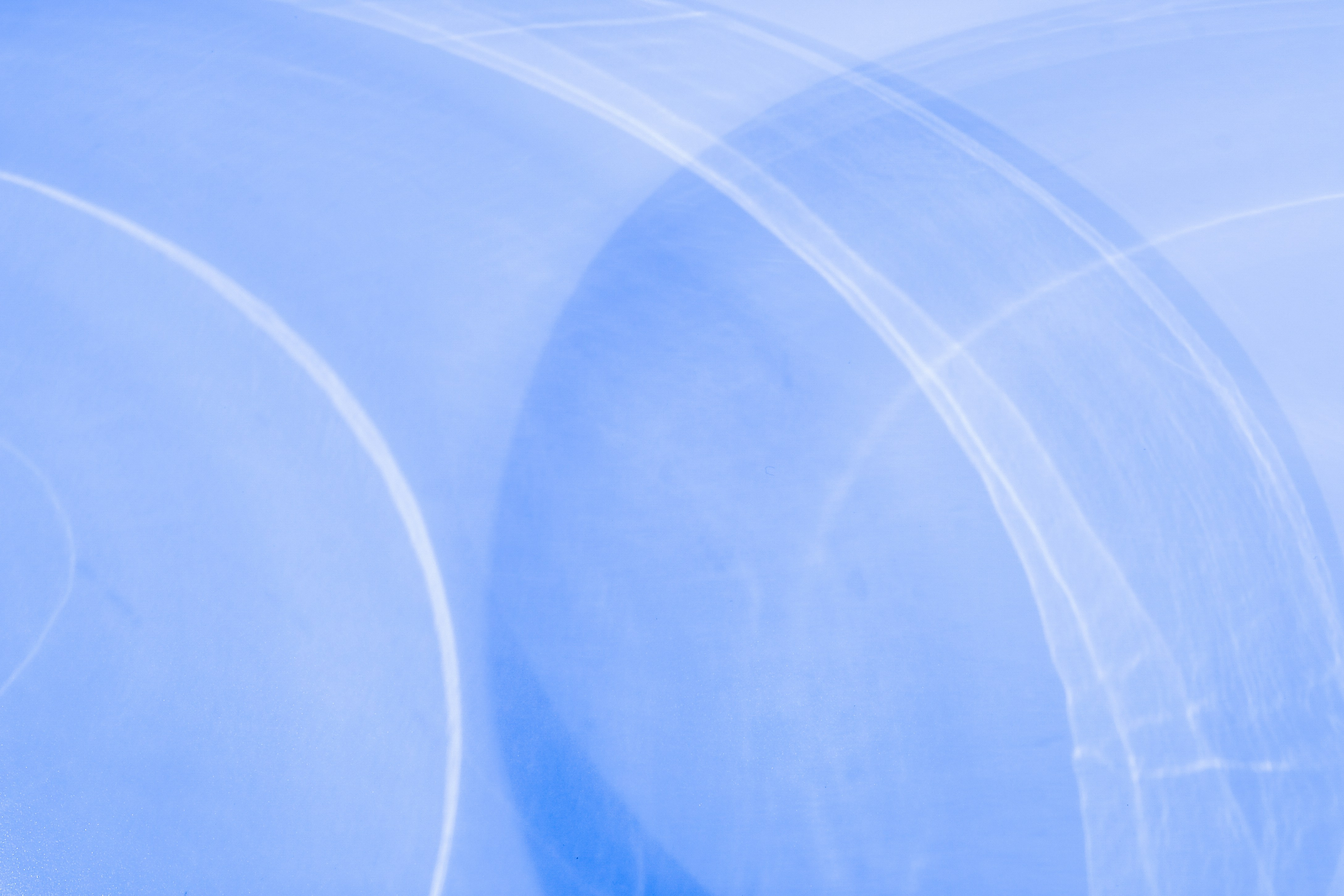 Abstract composition featuring soft blue curves and lines creating a fluid visual rhythm. The interplay of light and shadow adds depth to the scene.