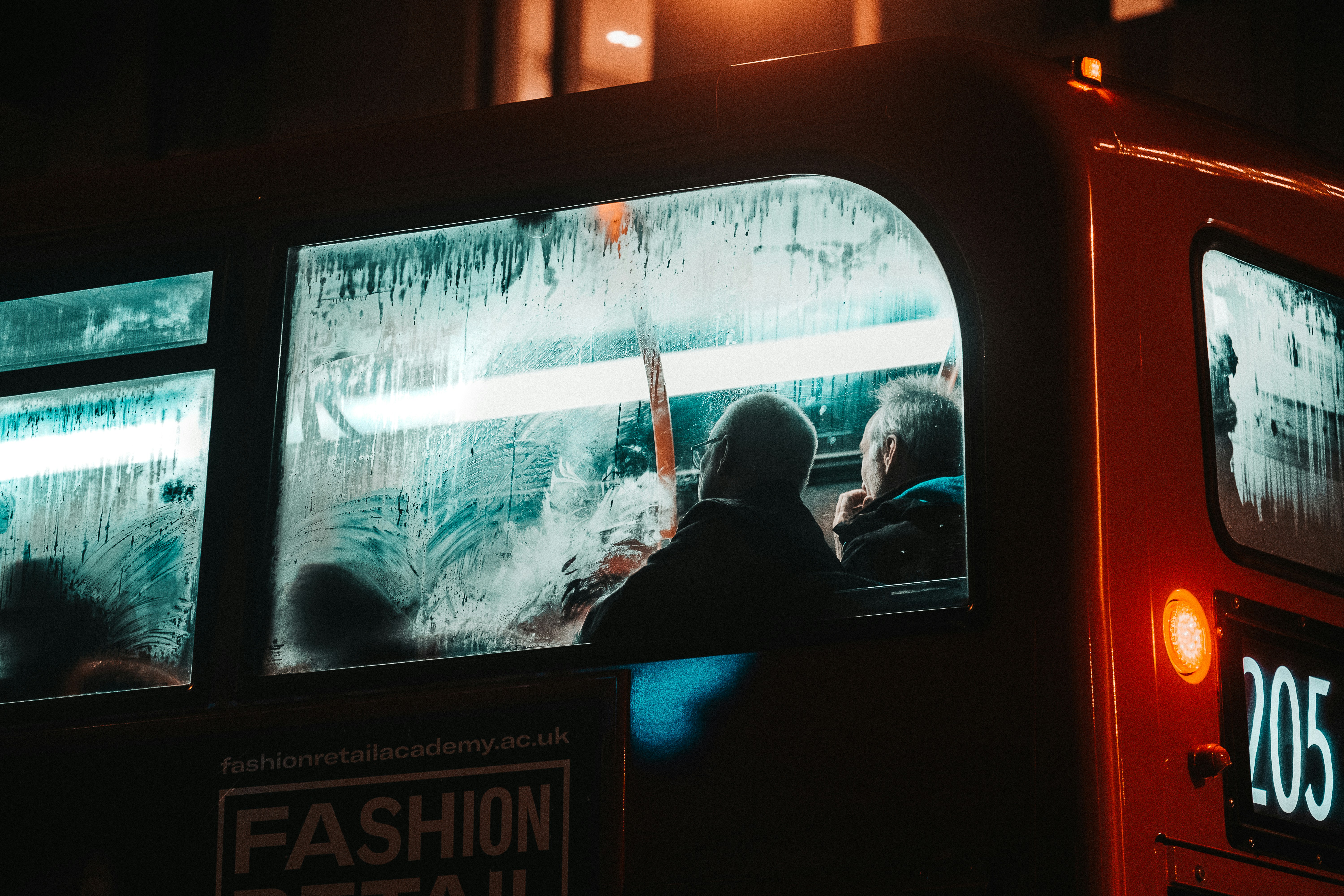 Midnight Window: Silhouettes on a Frosted Bus