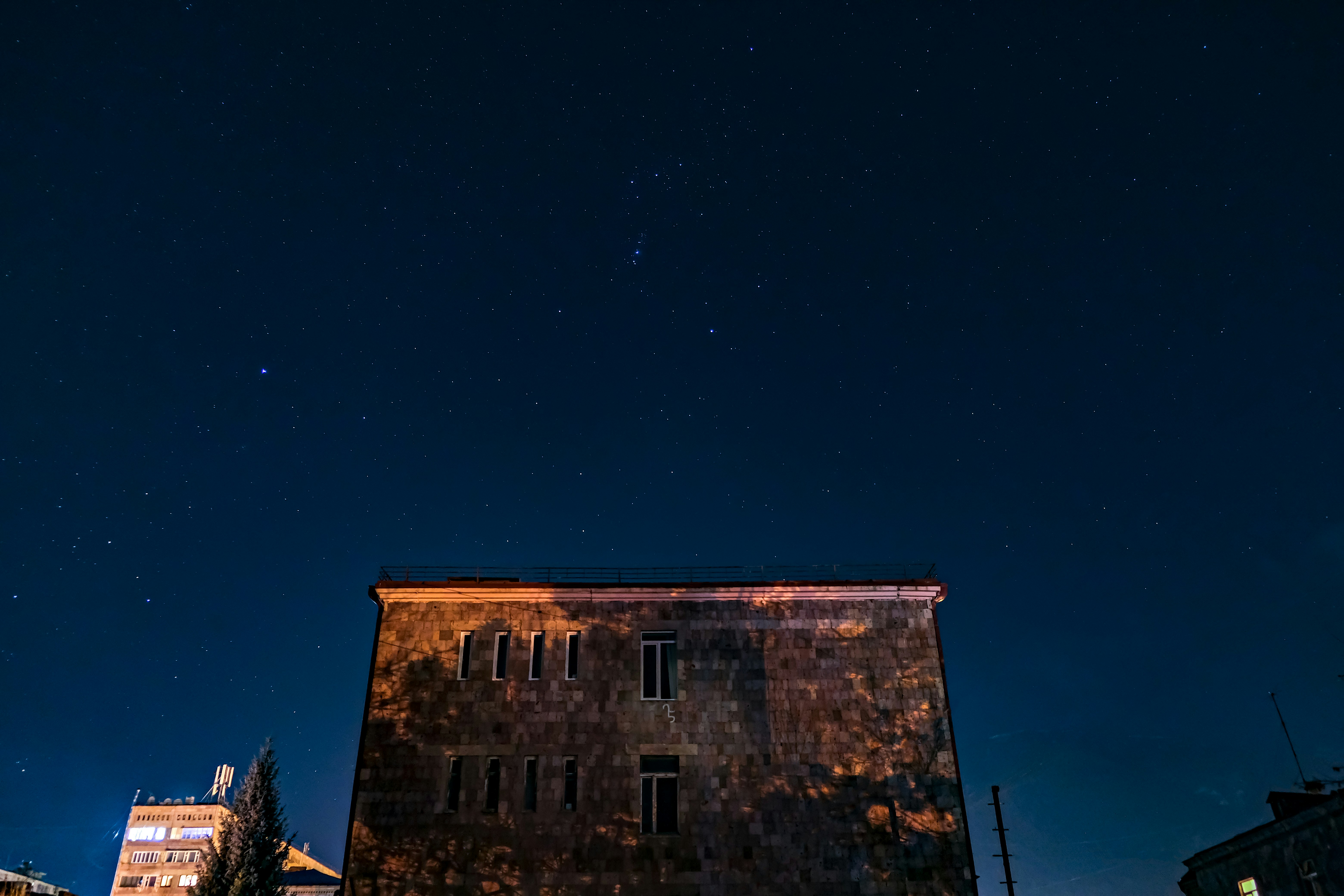 City building under a clear, star-filled night sky.
