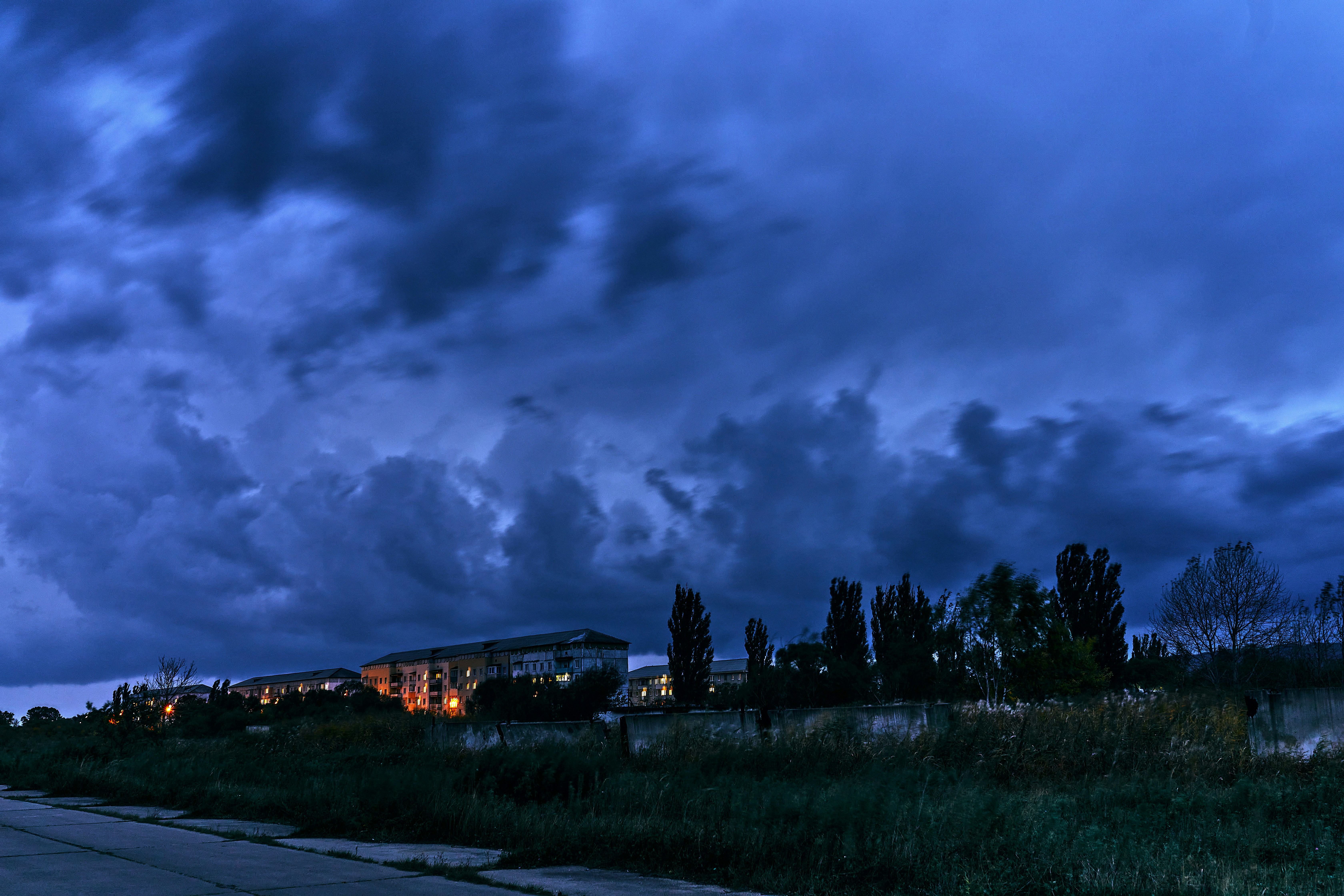Warm Windows on a Quiet Campus Verge Under a Turbulent Blue Night