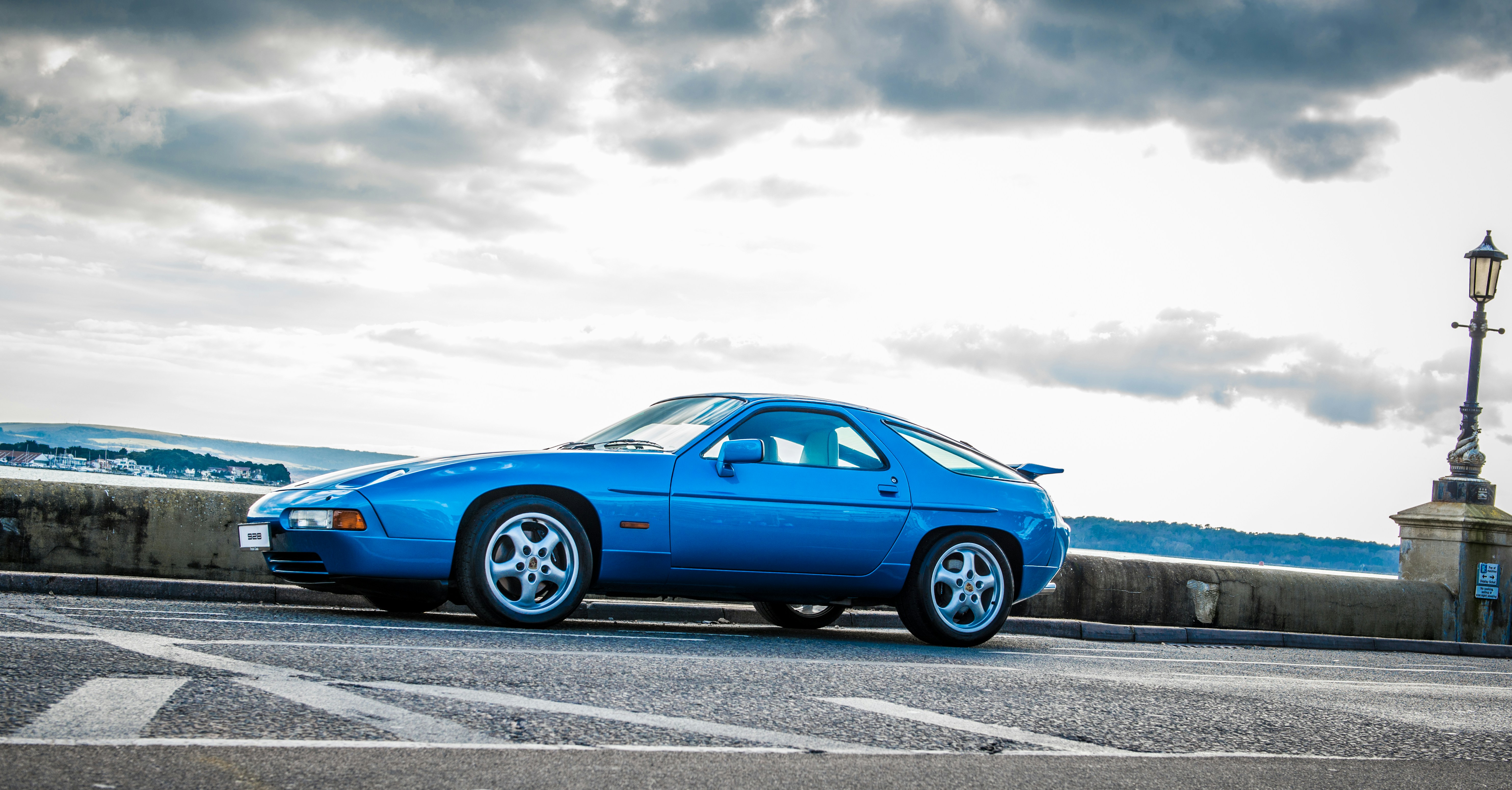 Blue Dusk: A Classic Coupe Rests by the Seaside Promenade