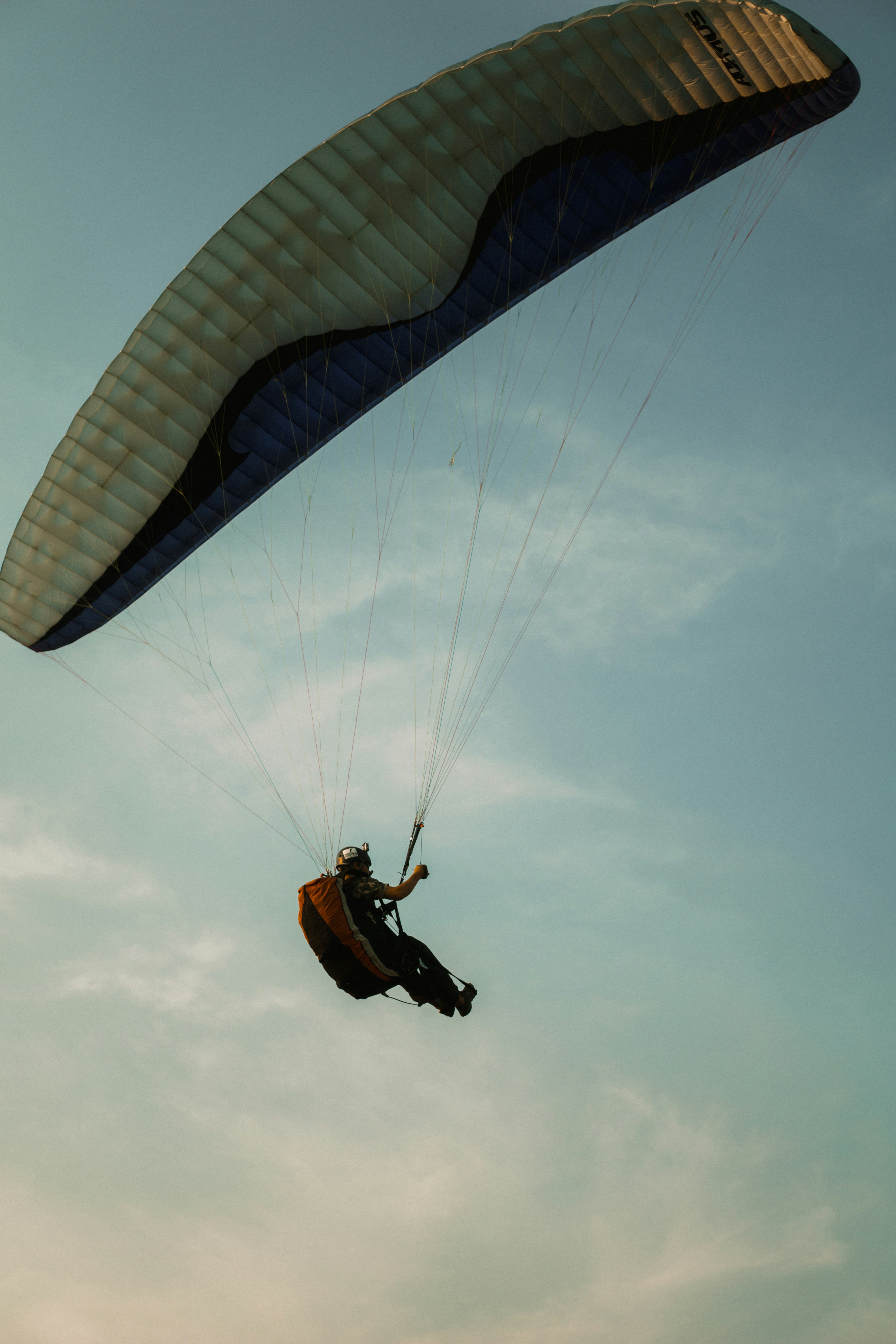 Windward Silhouette: Paraglider Cutting Across a Pale Sky