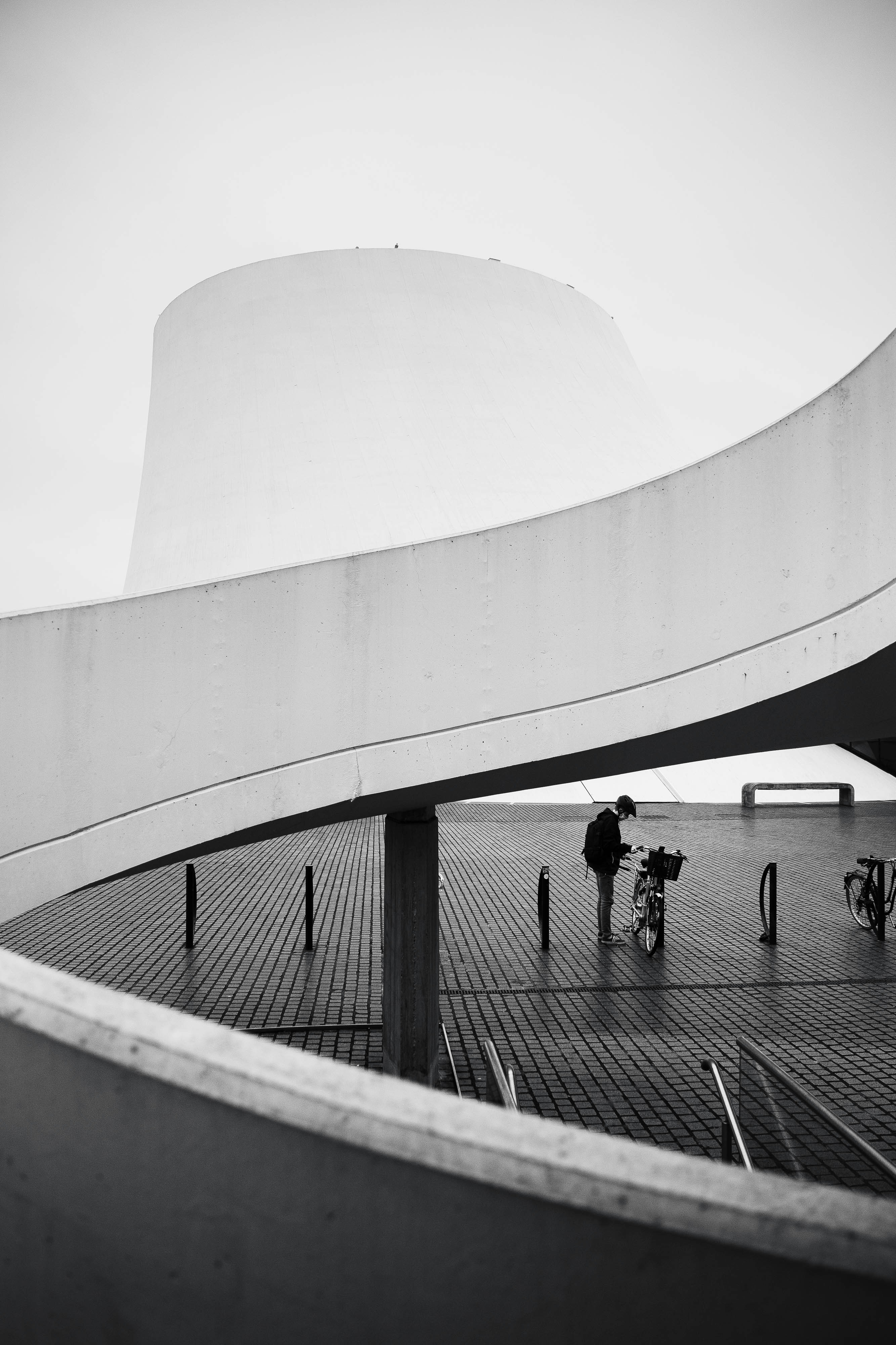 people walking on a bridge in grayscale photography