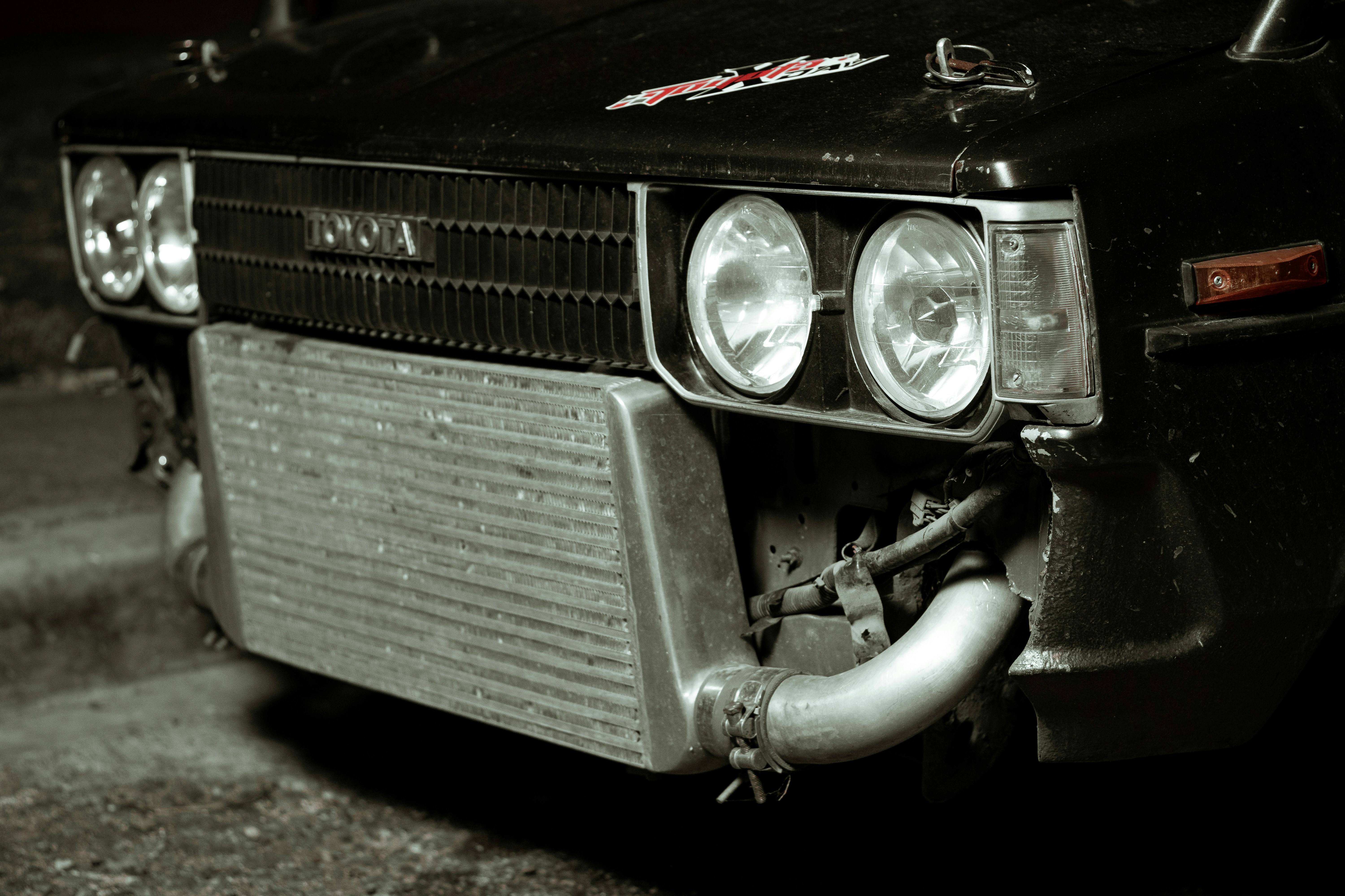 Weathered Front End of a Classic Toyota: Exposed Intercooler and Dual Round Headlights