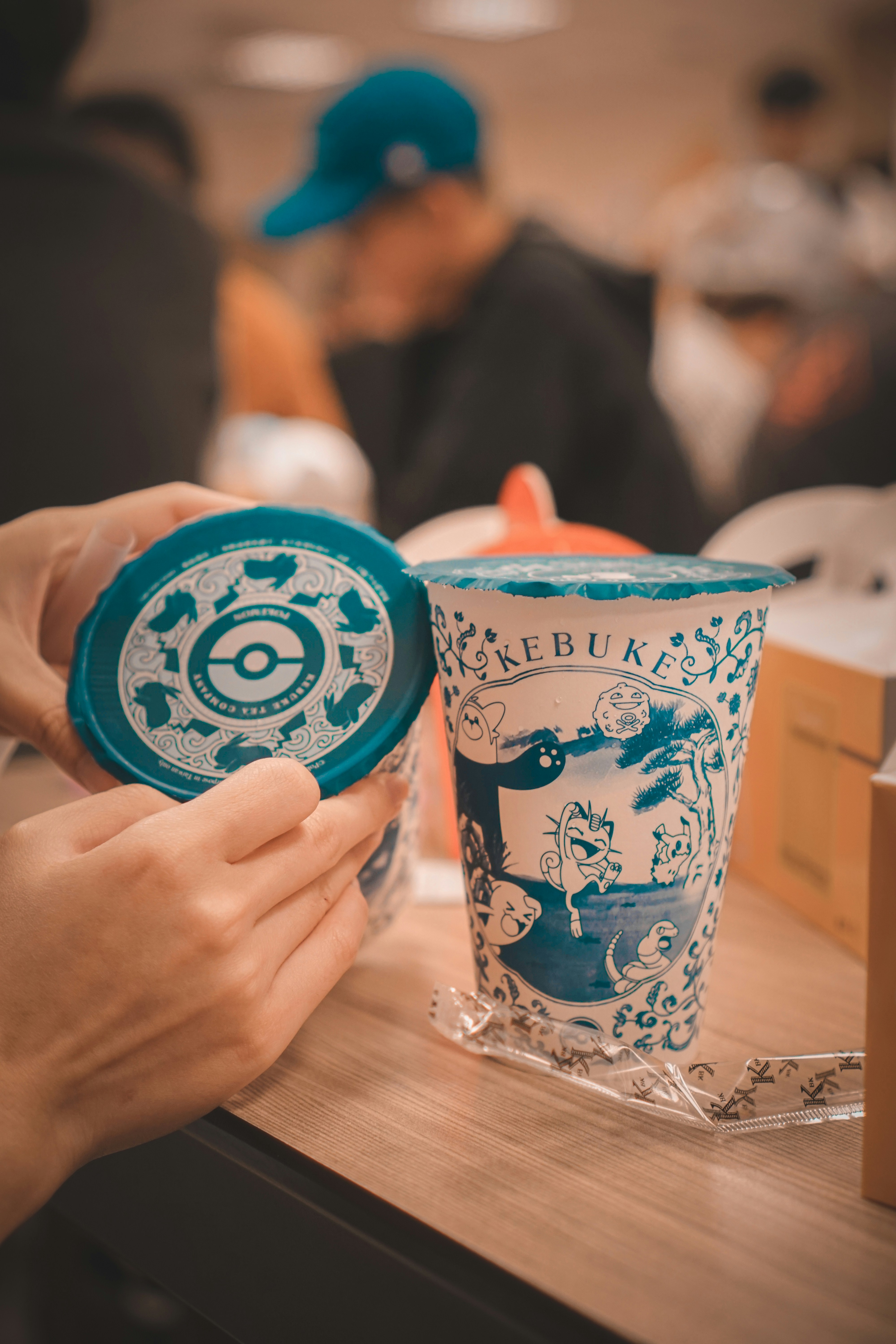 Teal Lid in Focus: A Quiet Café Moment Framed by Patterned Cup