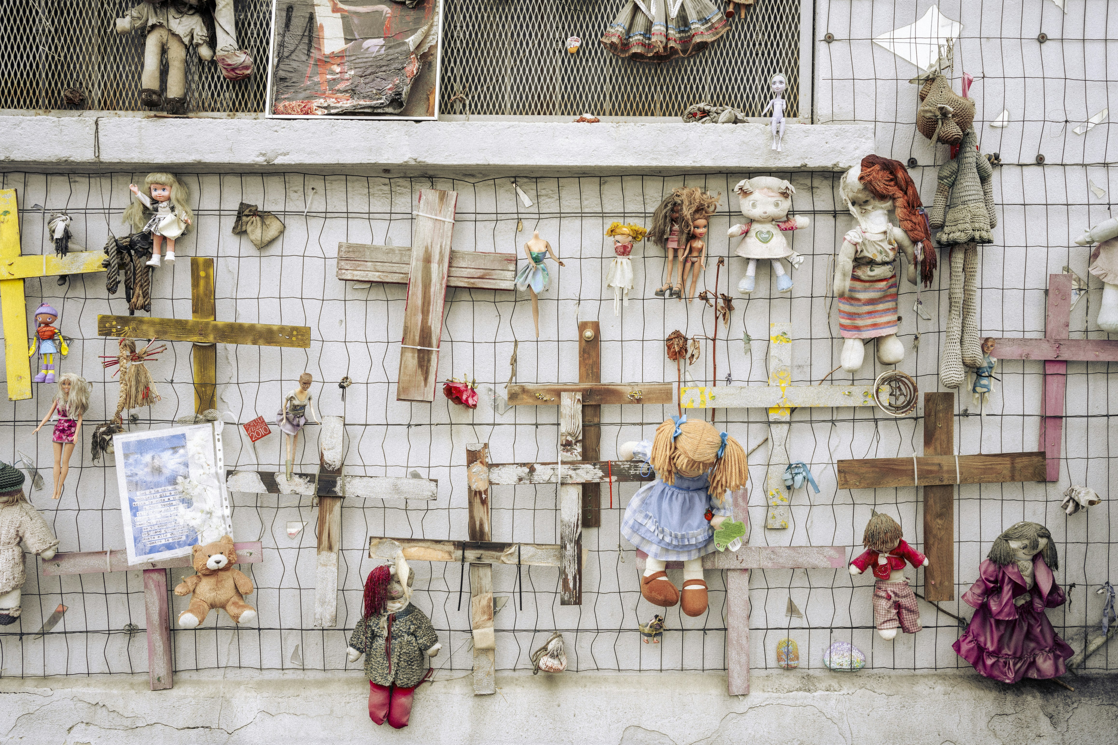 Tattered Whimsy: Dolls on a Wall of Crosses