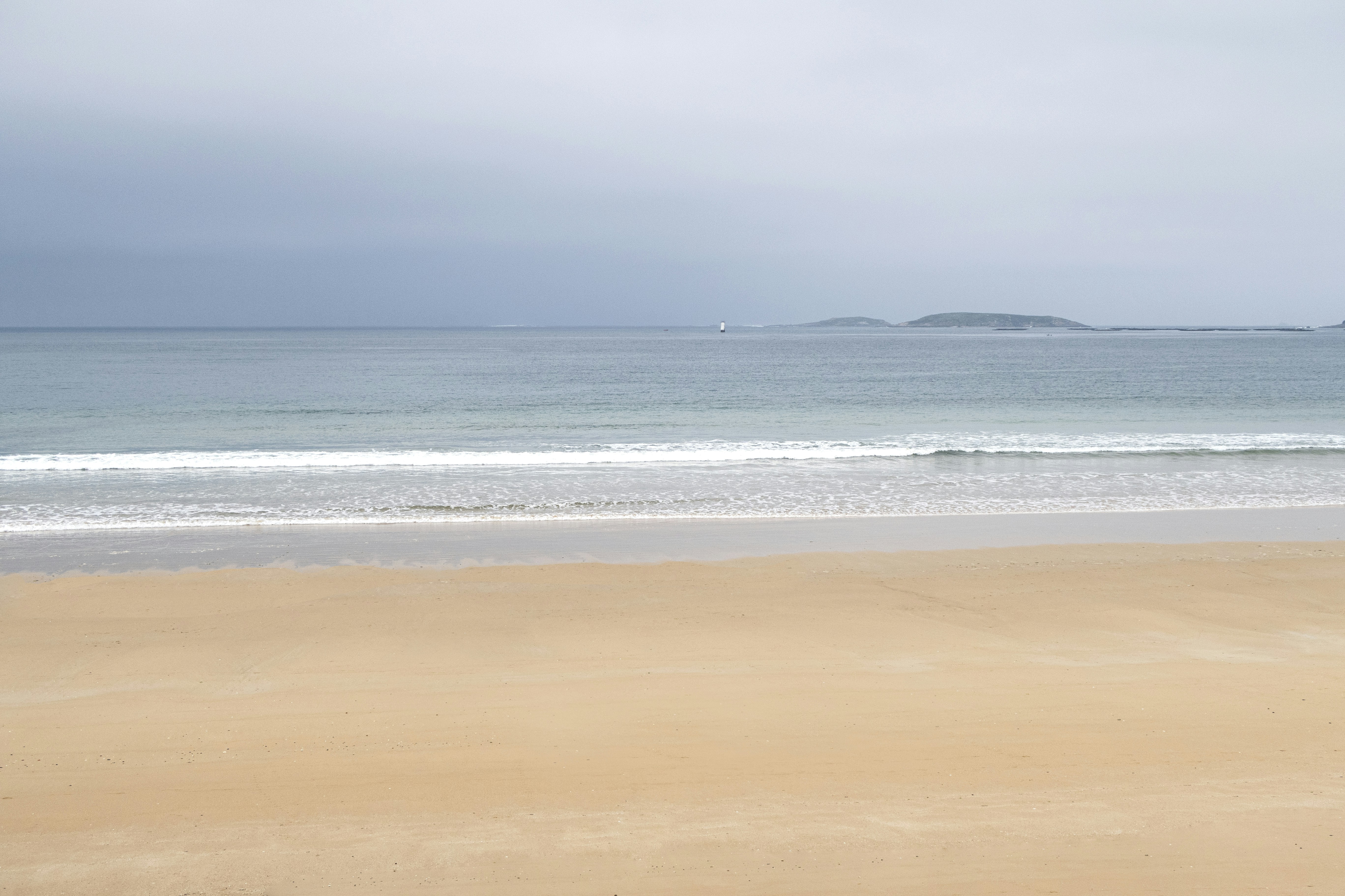 brown sand near body of water during daytime