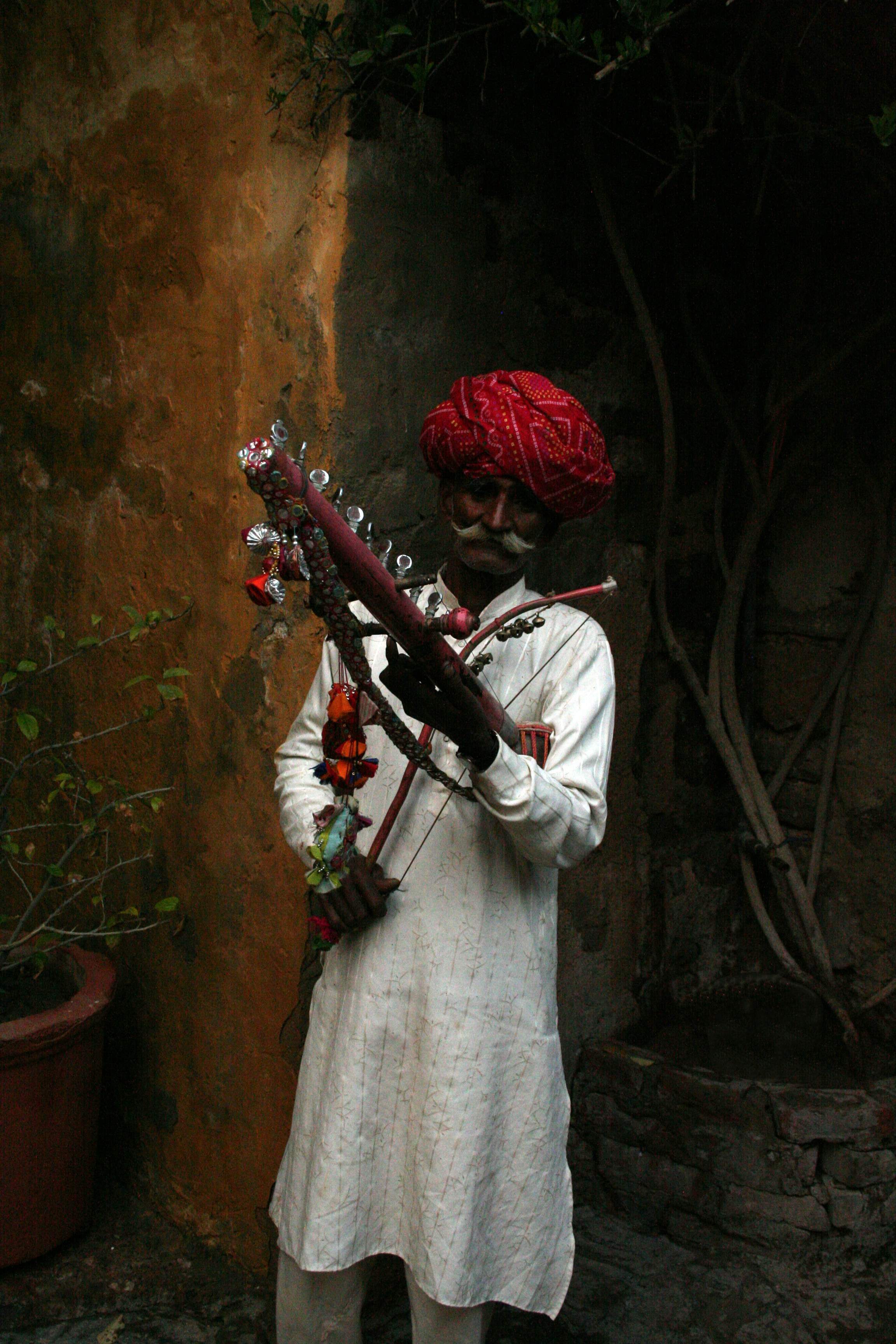 Strings in the Shadowed Courtyard: A Red-Turbaned Sitarist