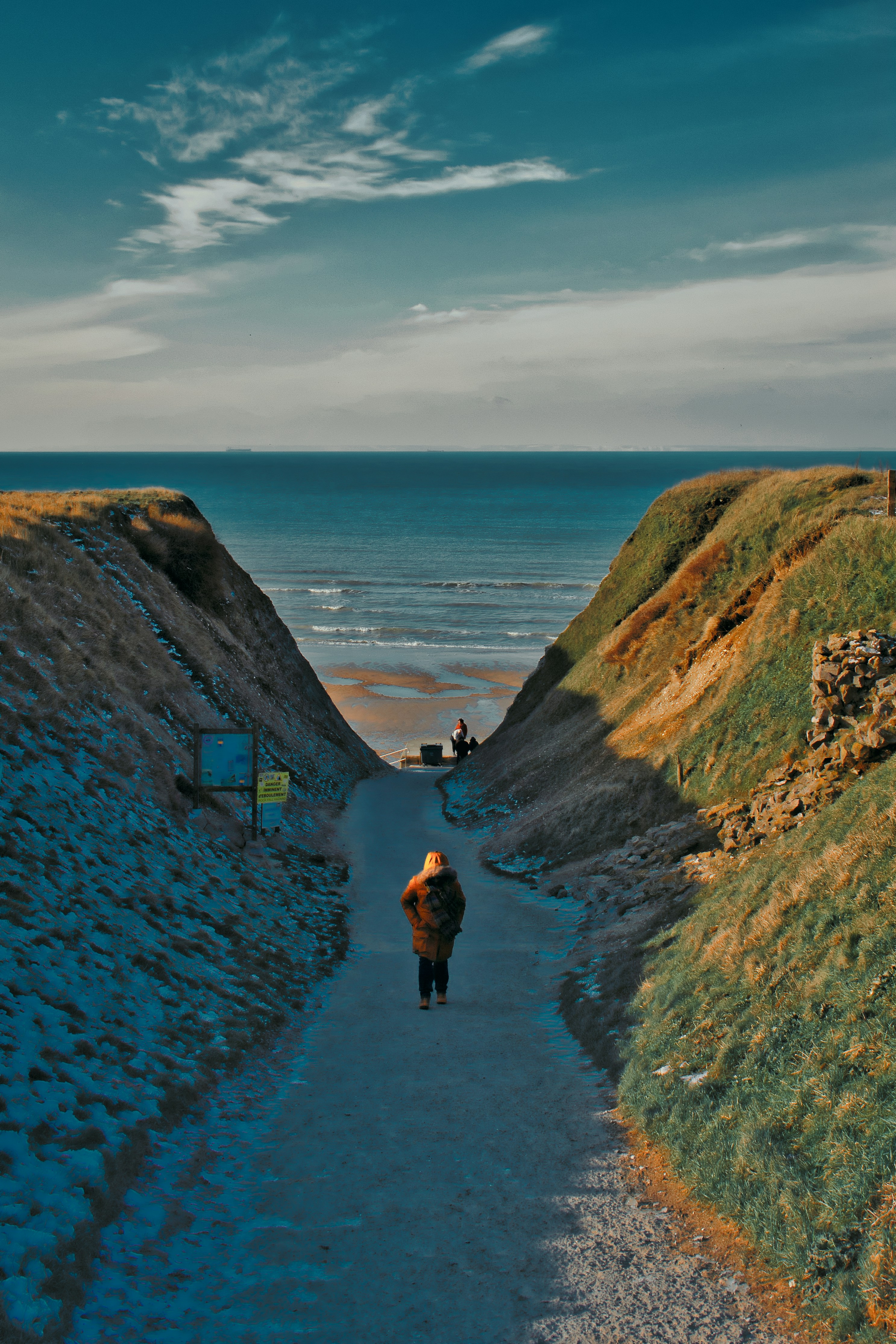 Footpath to the Sea: A solitary walker descends the dune corridor toward the horizon
