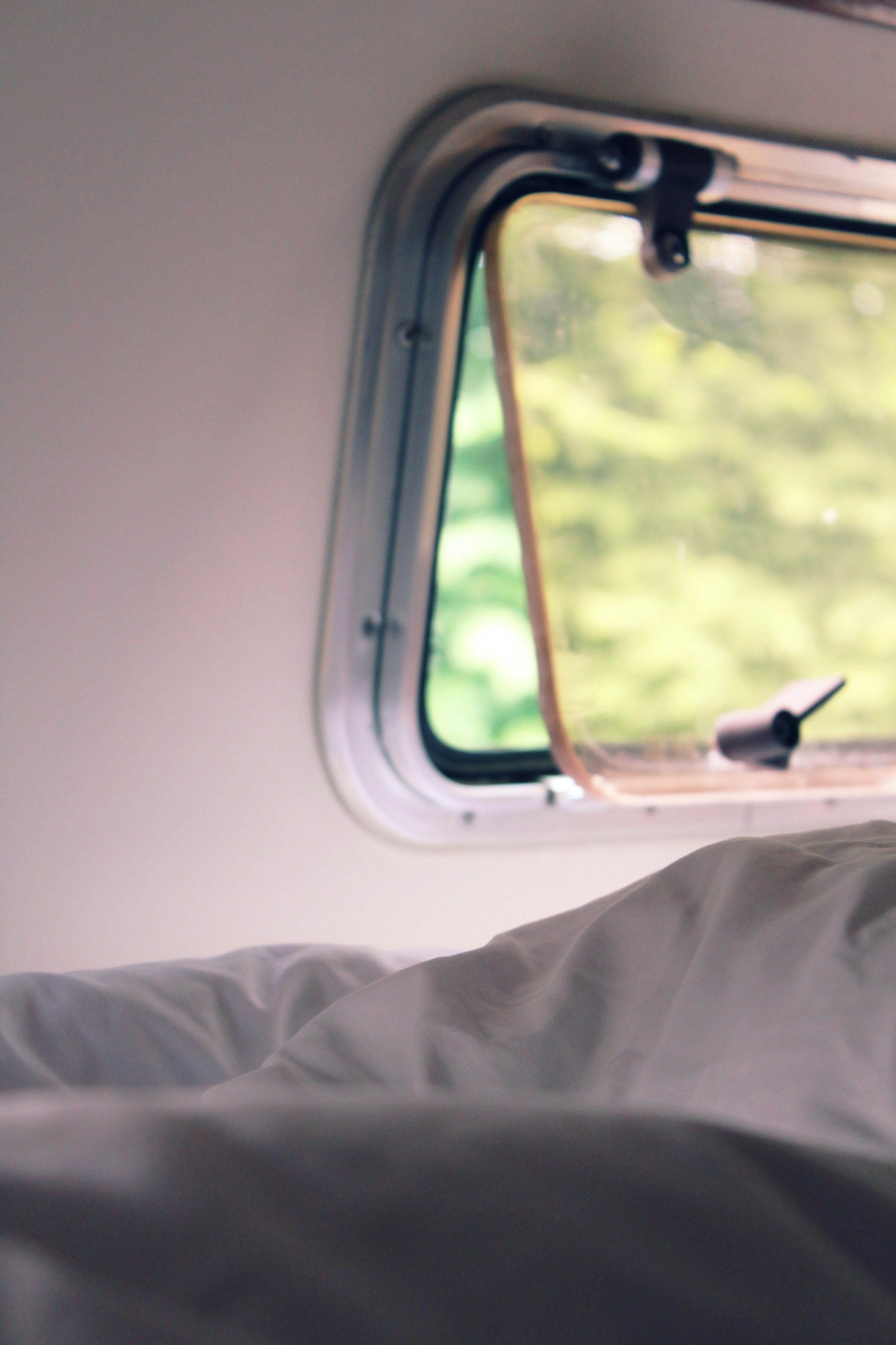 Porthole window and bedsheet cover in boat | black bird on white textile